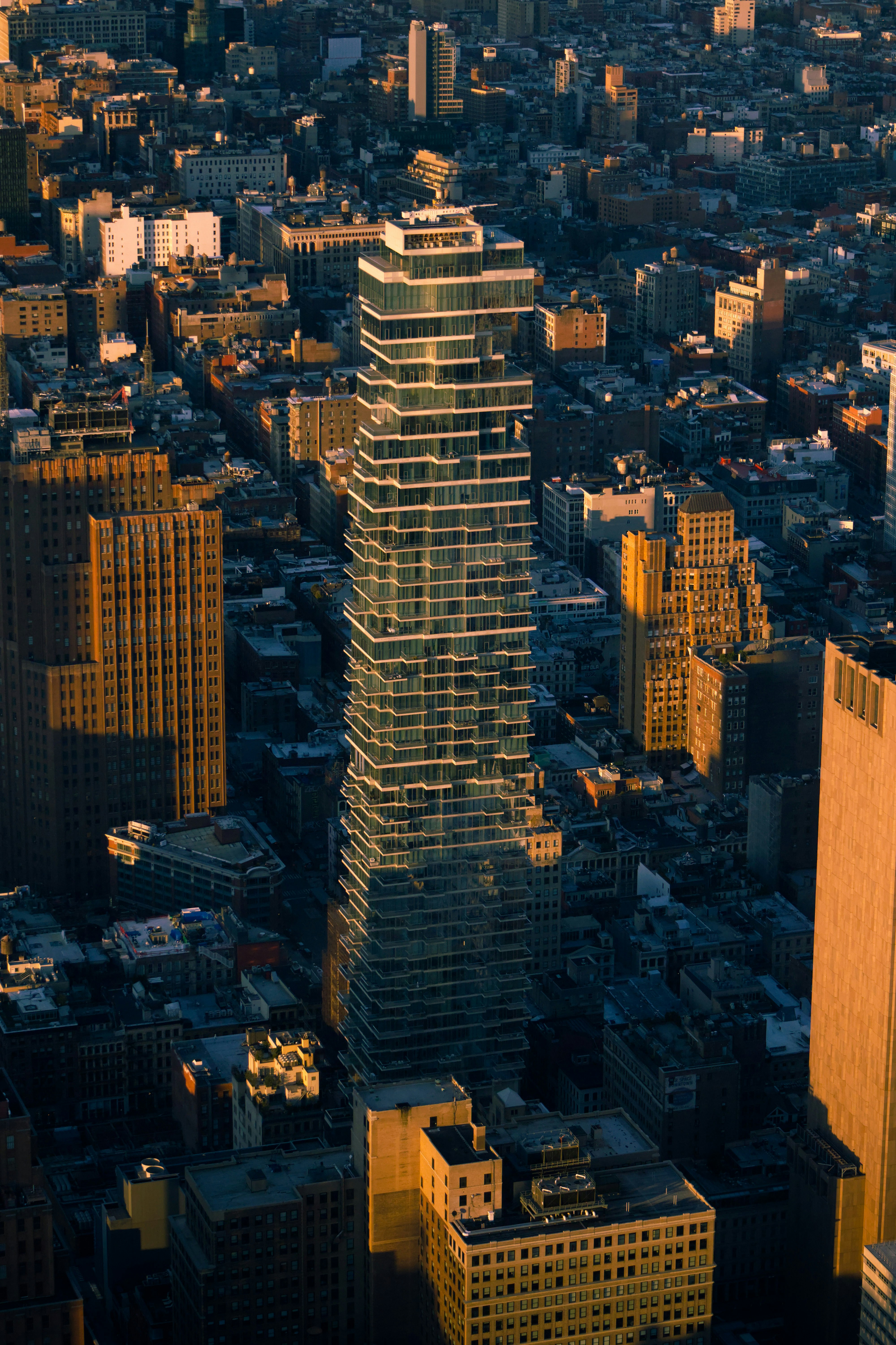 Tiered Glass Spire Bathed in Golden Hour Over a Dense Downtown Grid