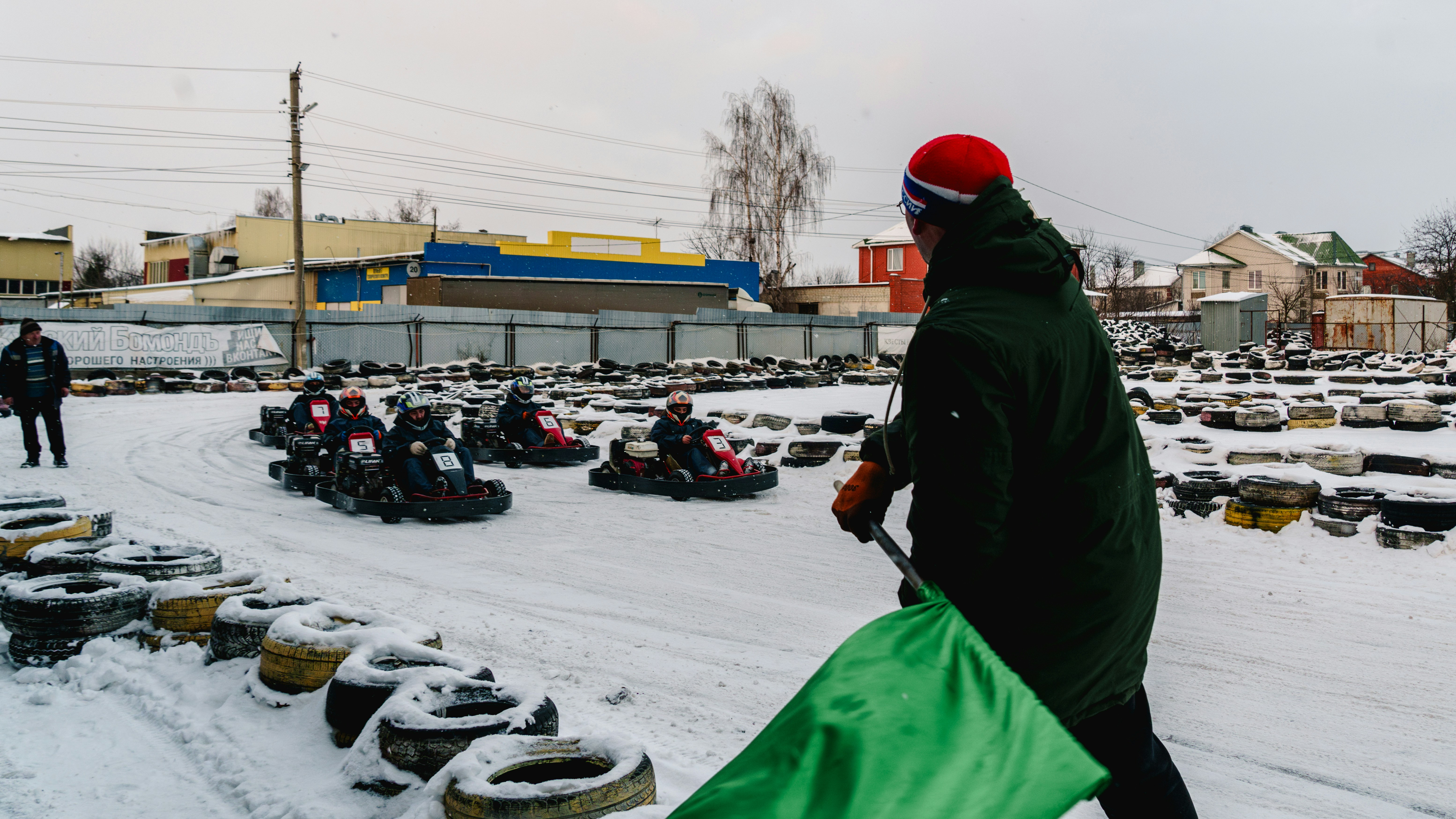 A group of people riding snowmobiles down a snow covered road photo ...