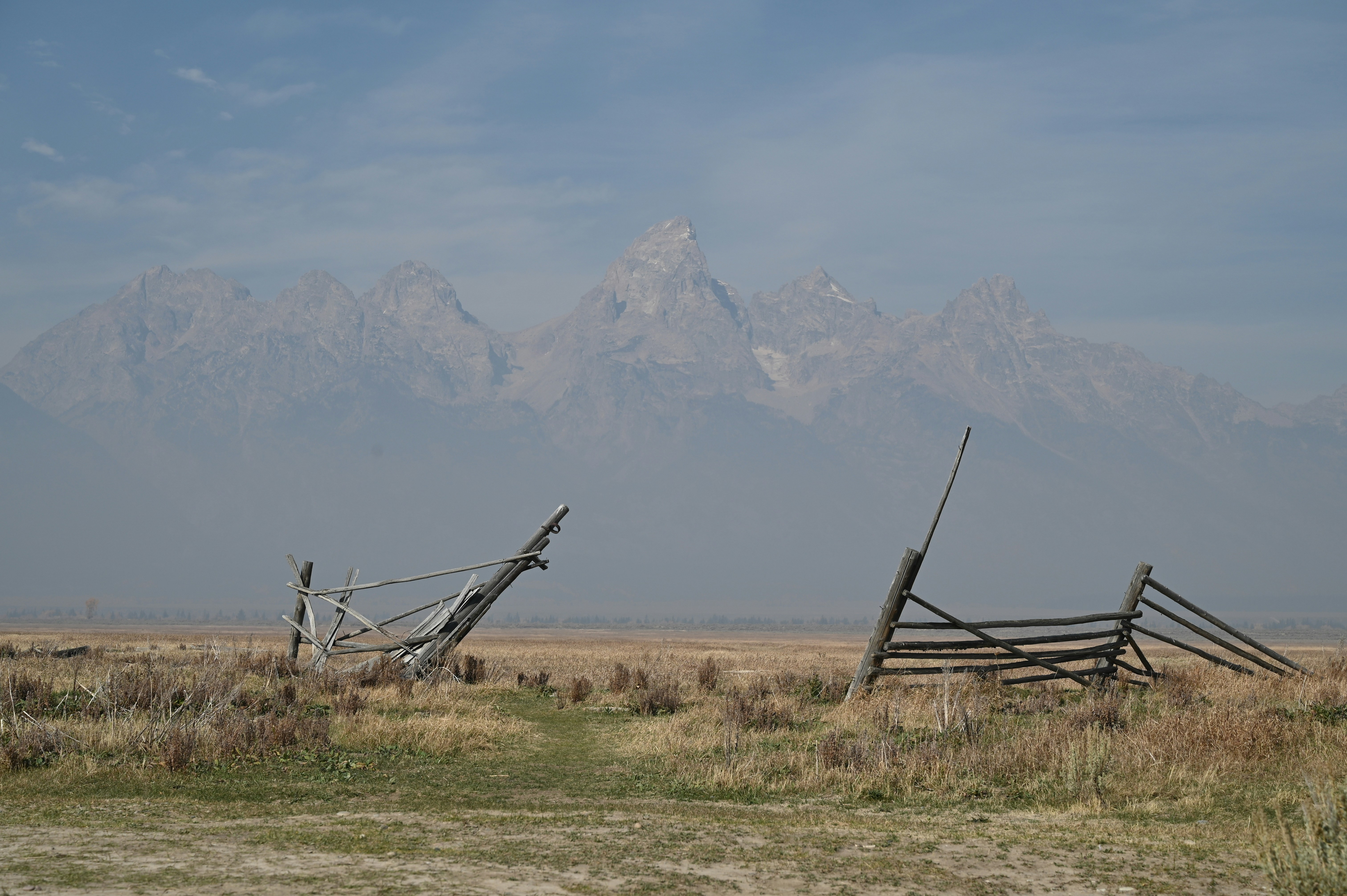 Weathered Rails Against a Prairie Quietly Framed by Distant Alpine Peaks