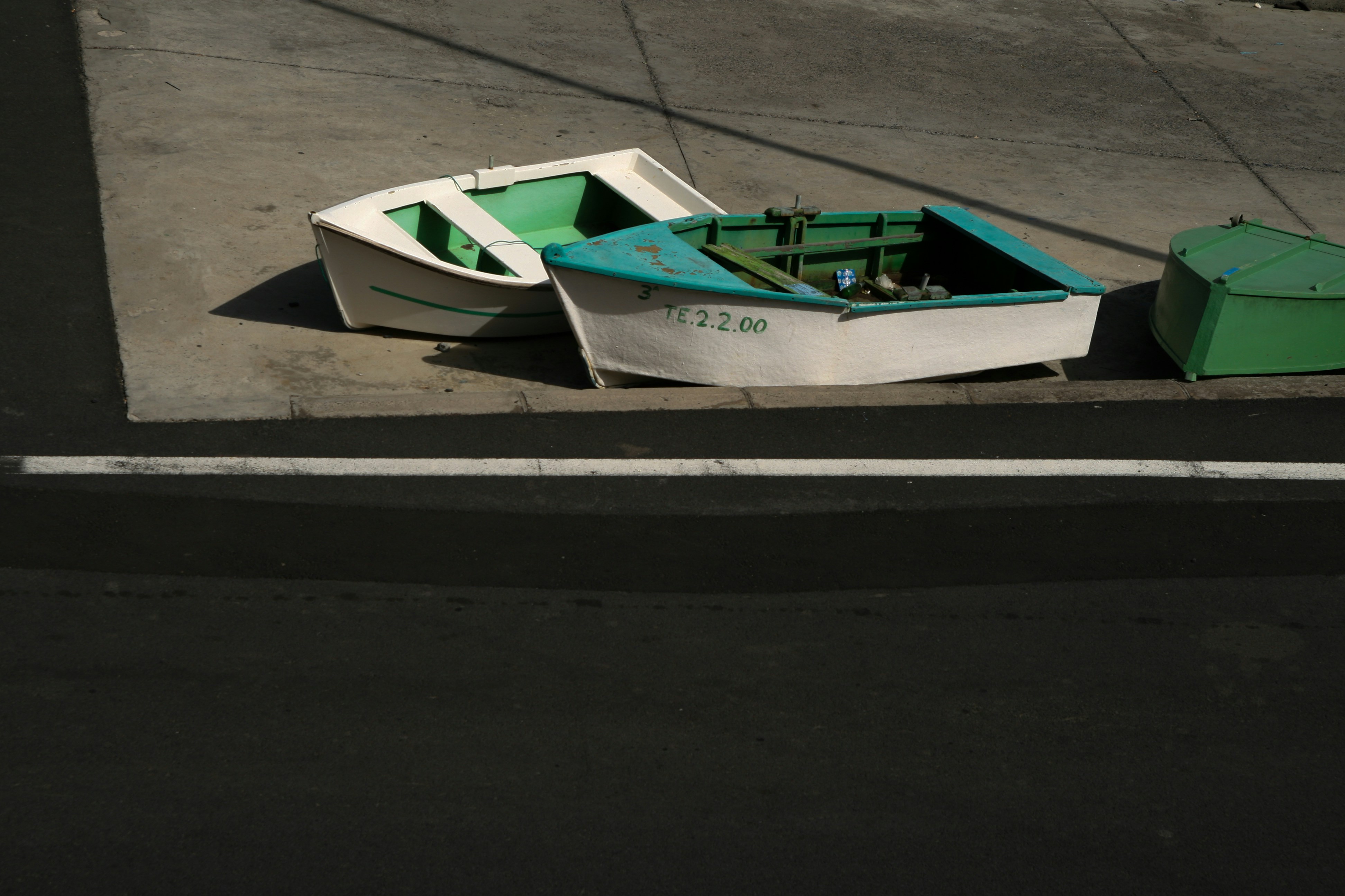 A couple of small boats sitting on the side of a road photo – Free Road ...