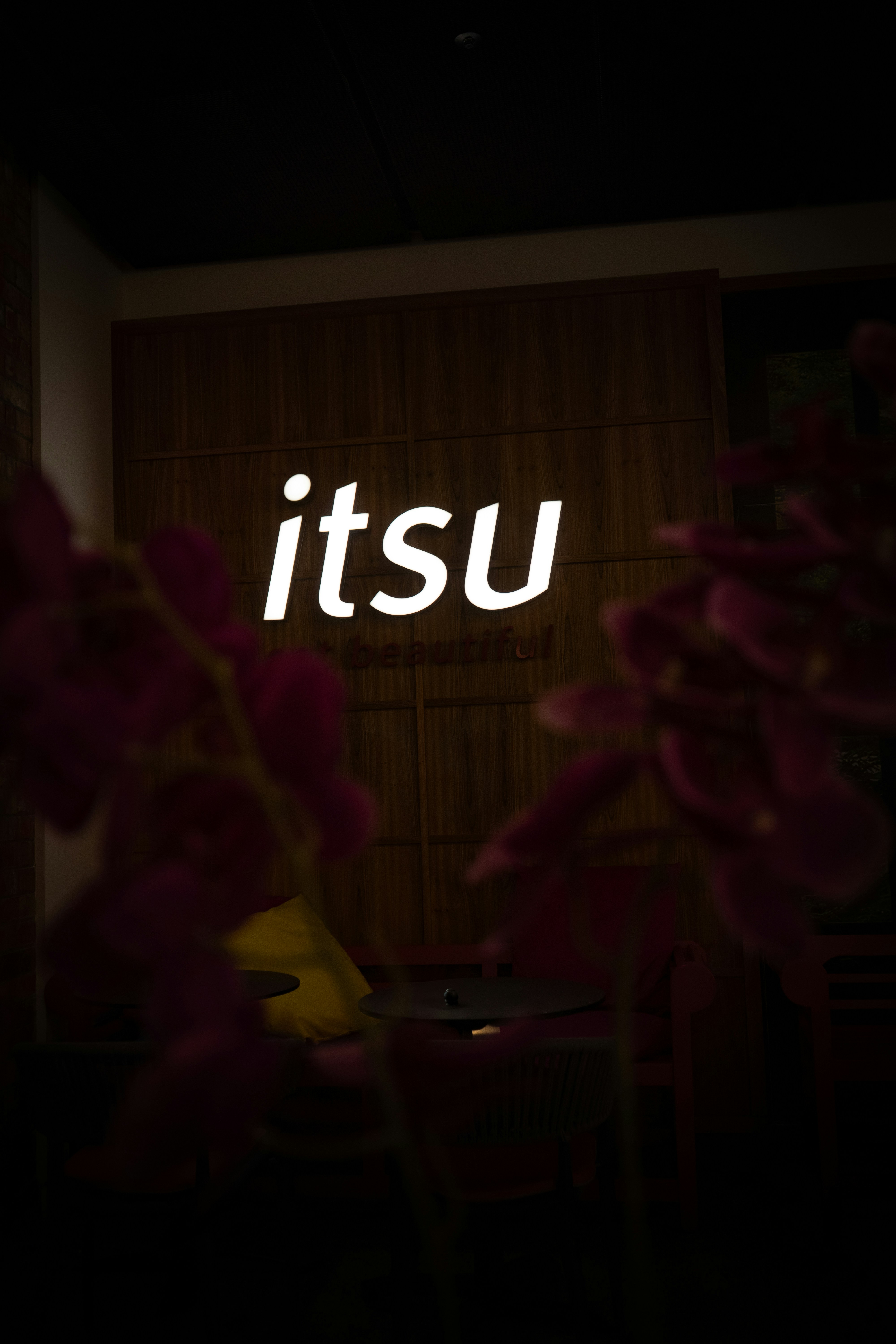 A lit up sign that reads itsu in a dark room photo – Free Itsu ...