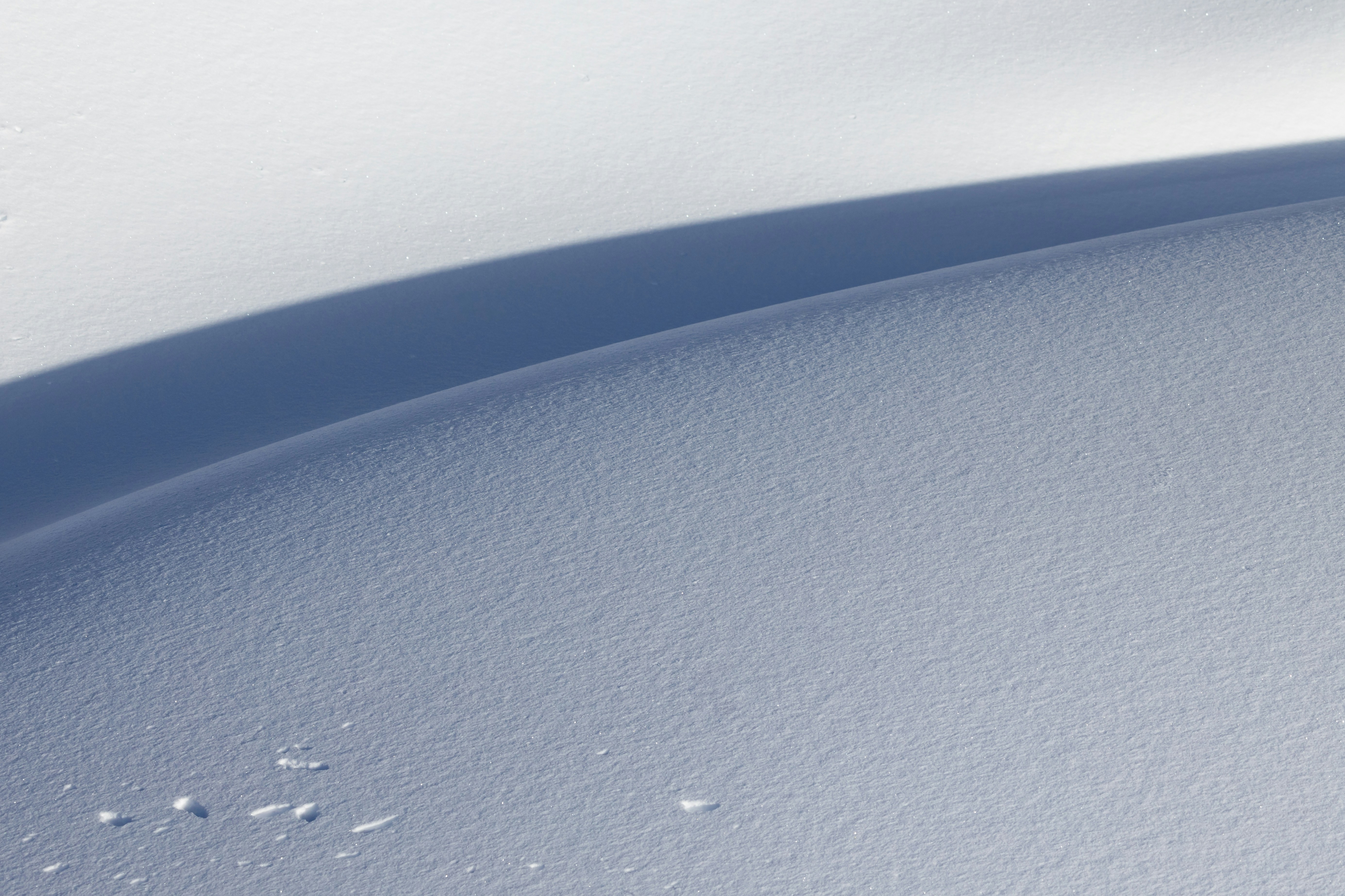 A perfect snowbank with a bit of imperfection | A snowboarder is going down a snowy hill