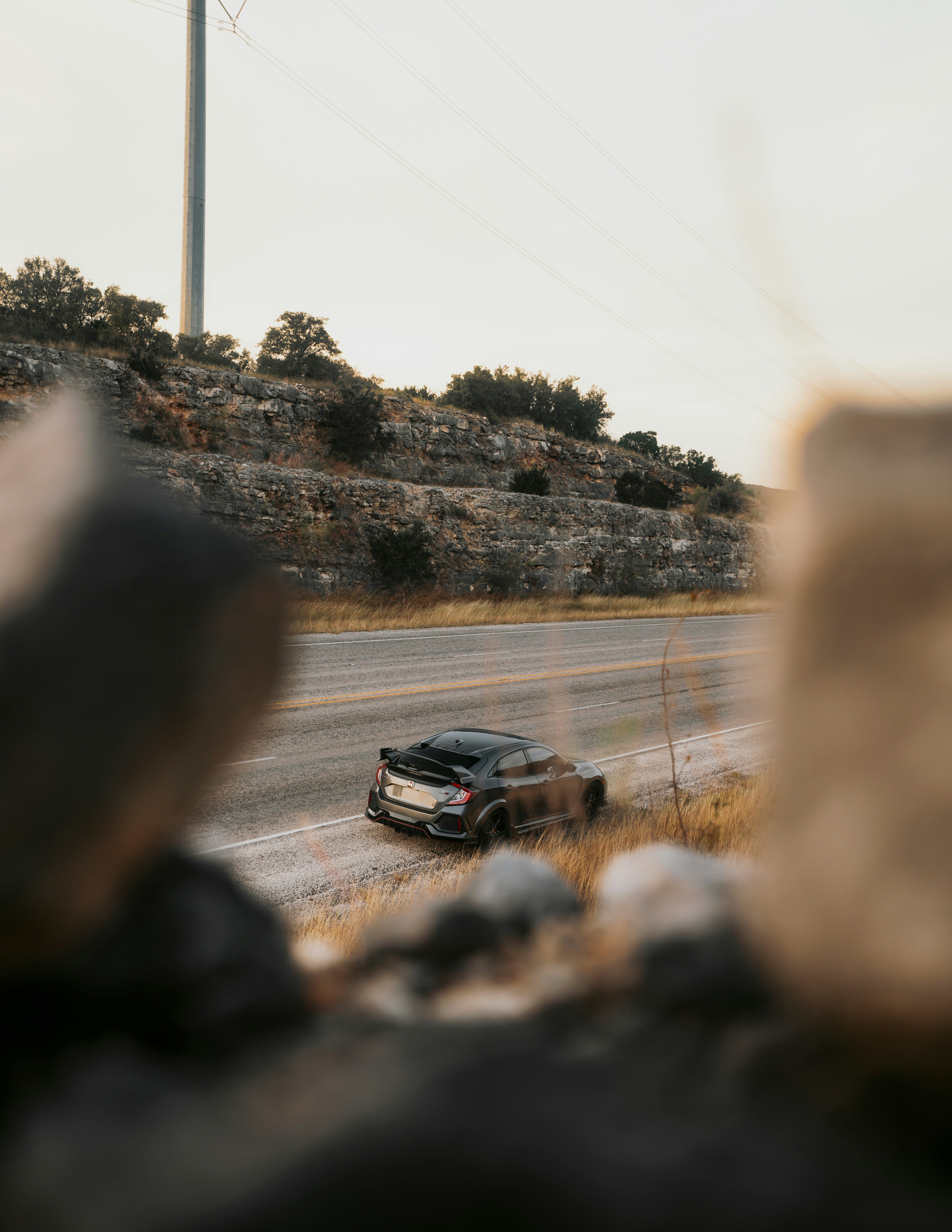 A car driving down a road next to a hill photo – Free Civic type r ...