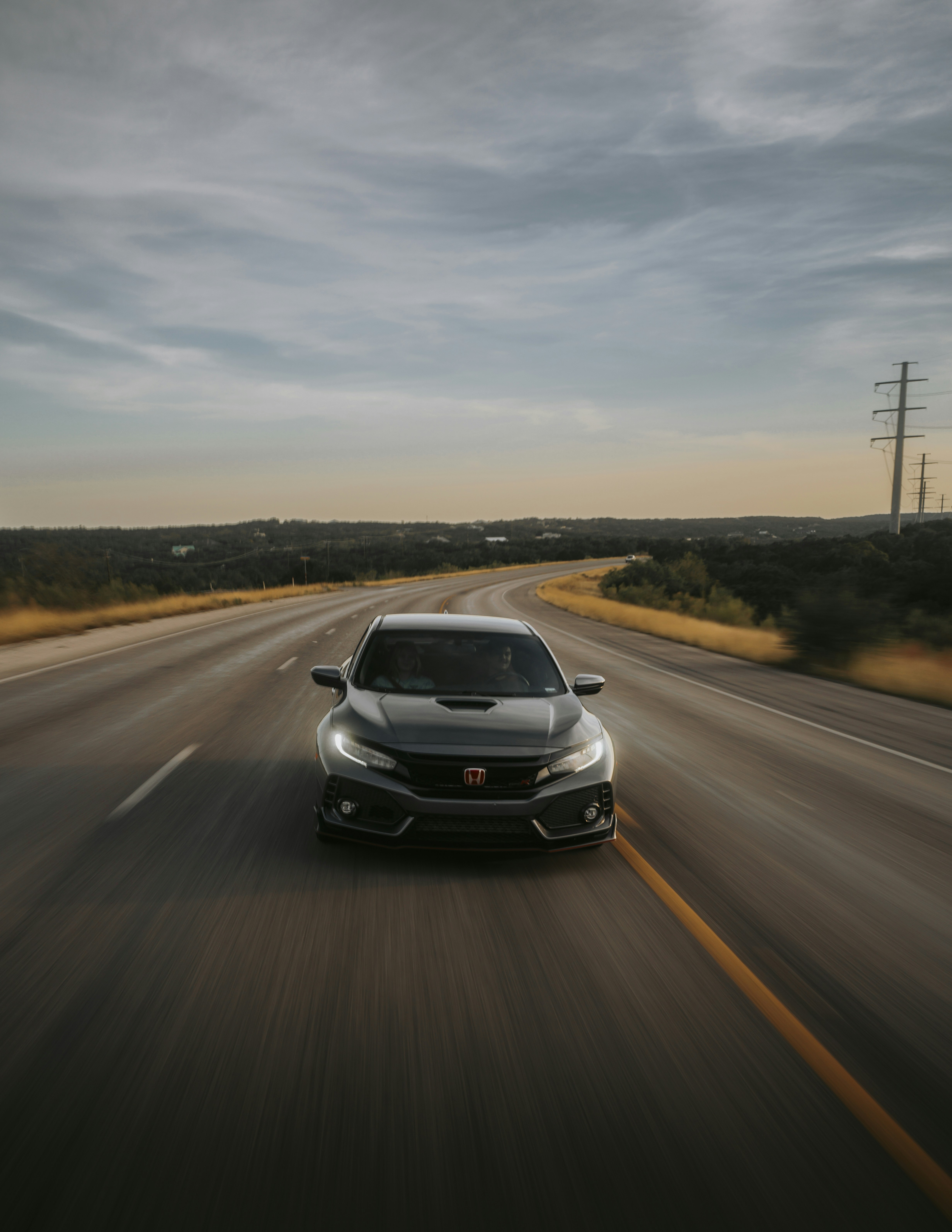 A car driving down a road with a sky background photo – Free Civic type ...