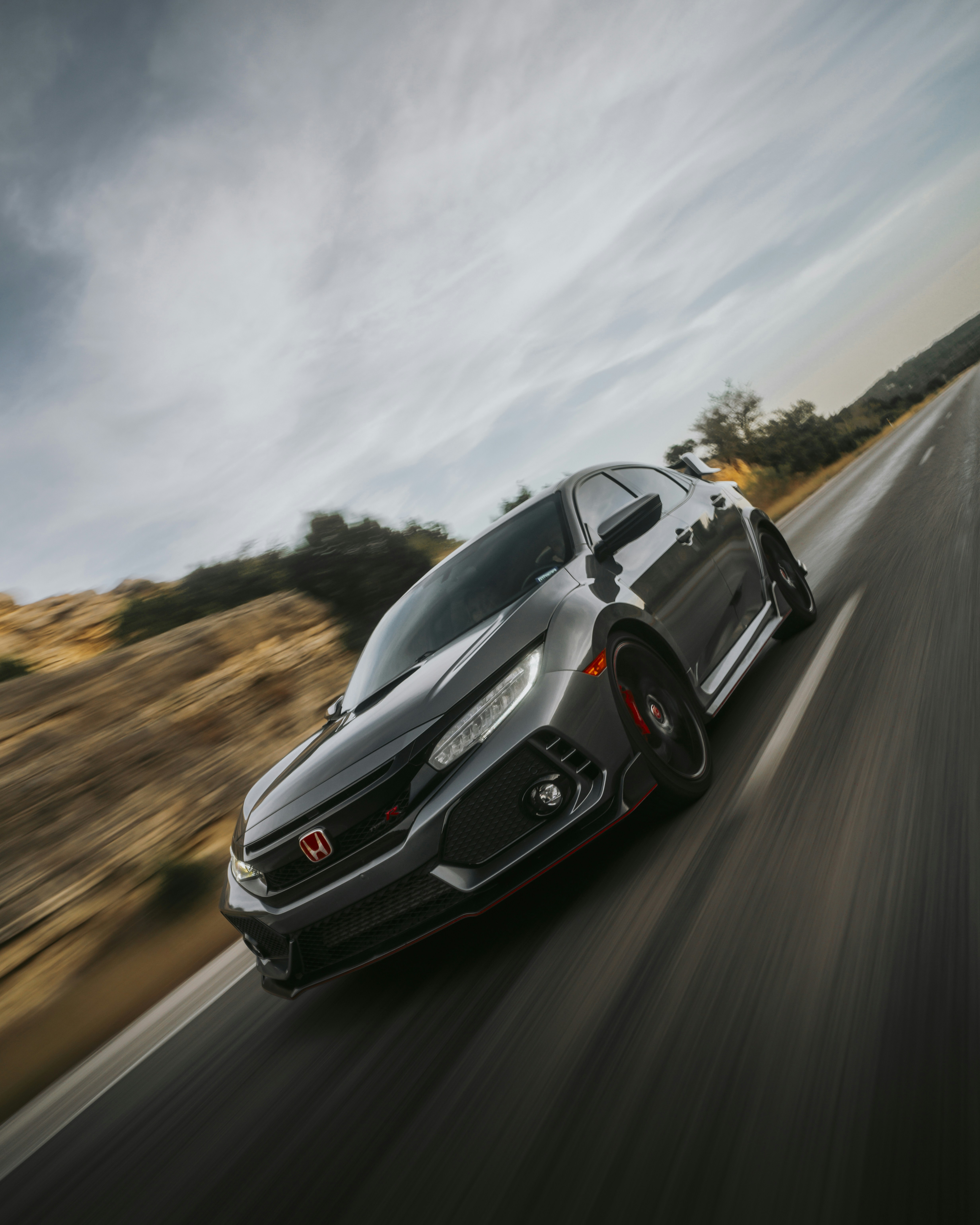 A black car driving down a road with a sky background photo – Free ...