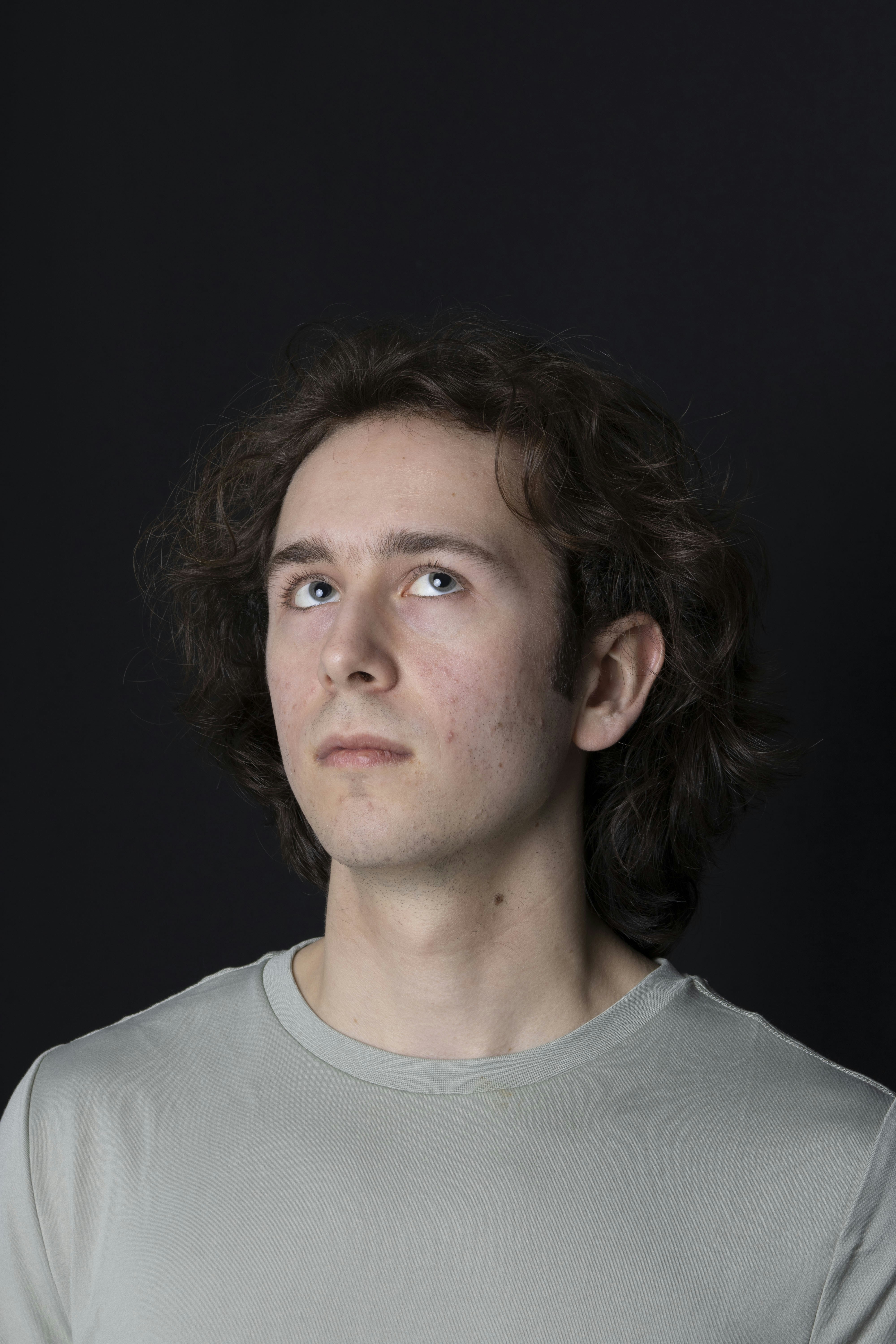 A man in a gray shirt looking up at something photo – Free Raw portrait ...