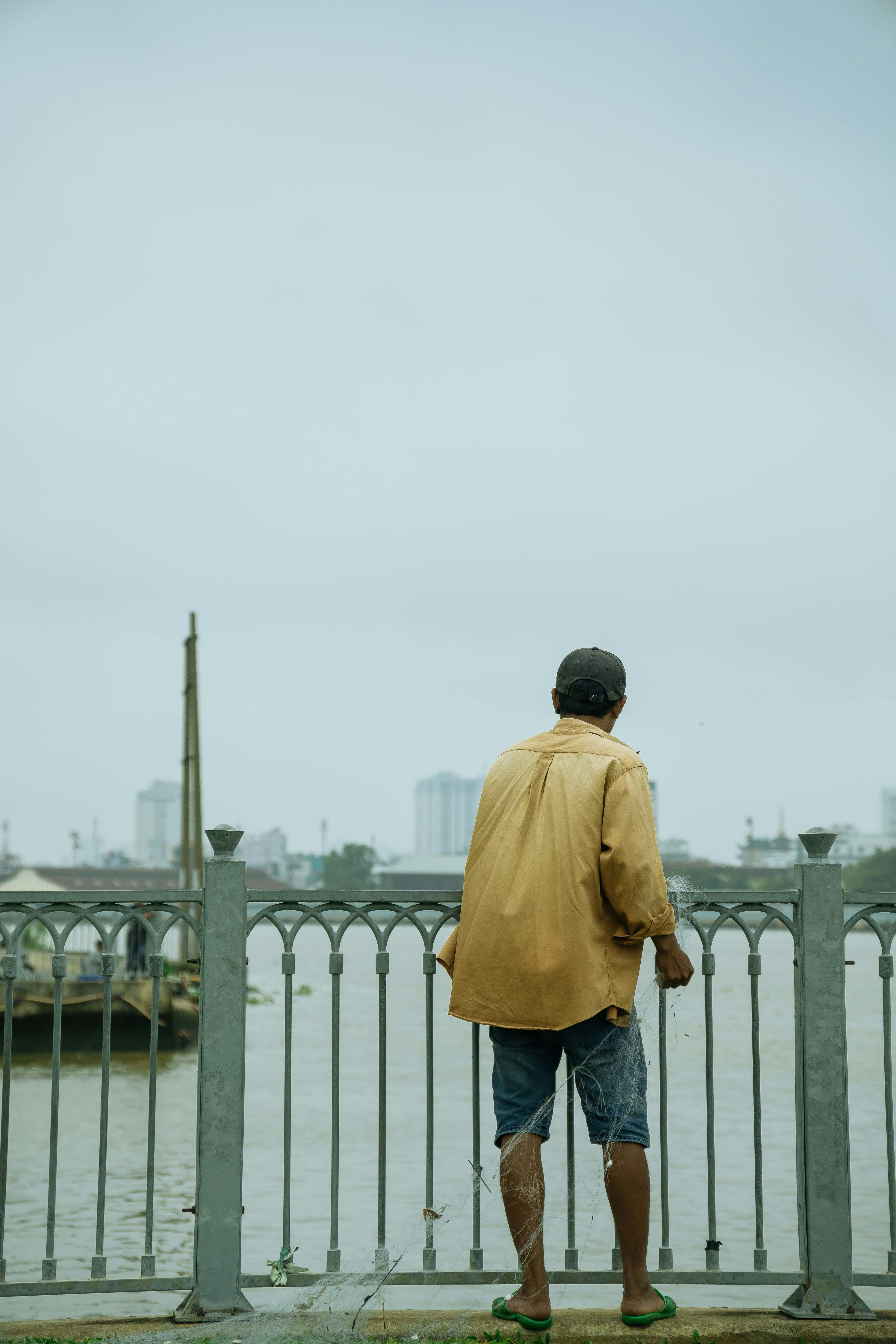 Overlooking the River: A Riverside Portrait of a Wanderer