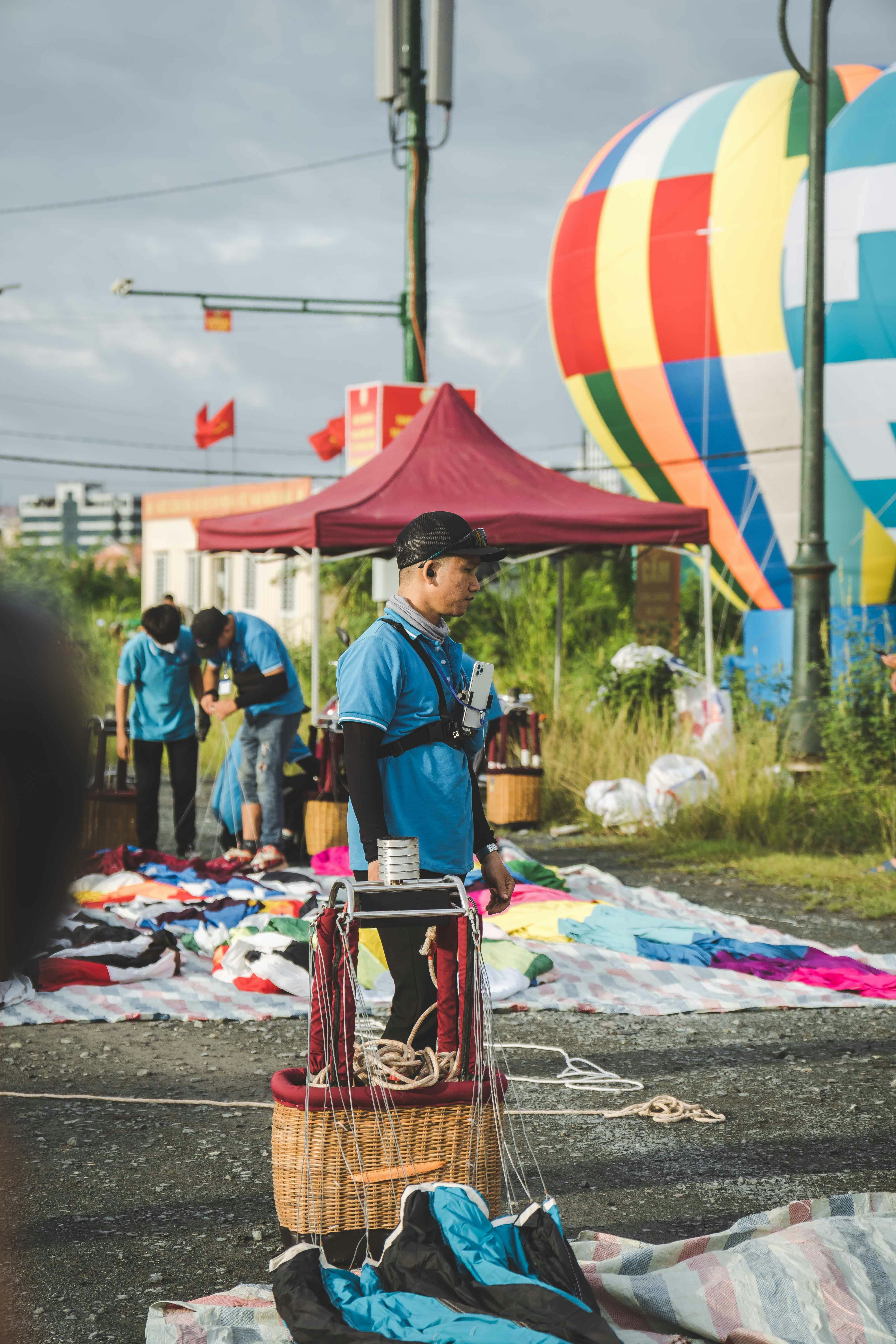 Blue-Shirt Vendor at a Market Under a Rainbow Balloon