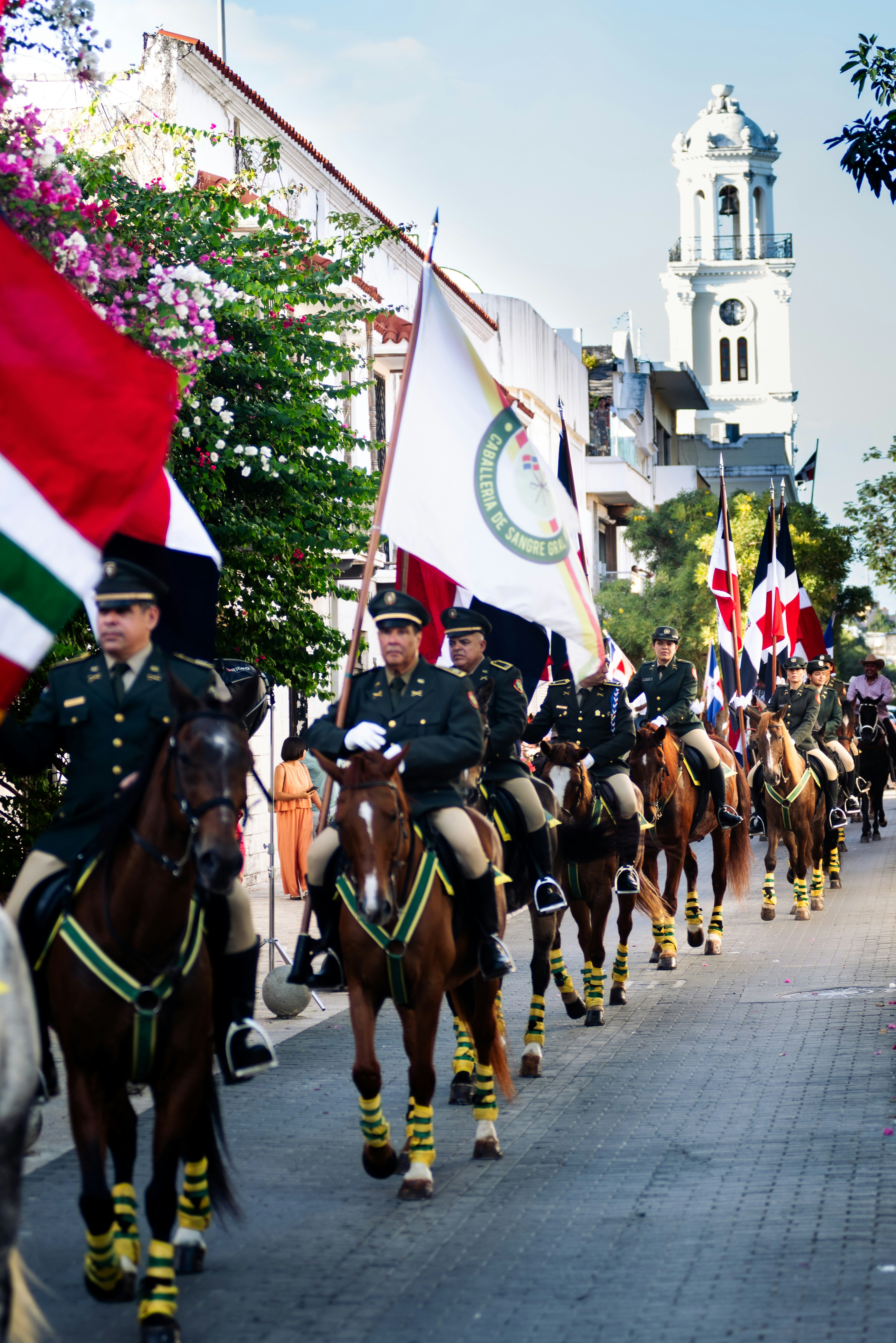 Cavalry Parade Under a Clock Tower: Flags, Uniforms, and a Sunlit Street