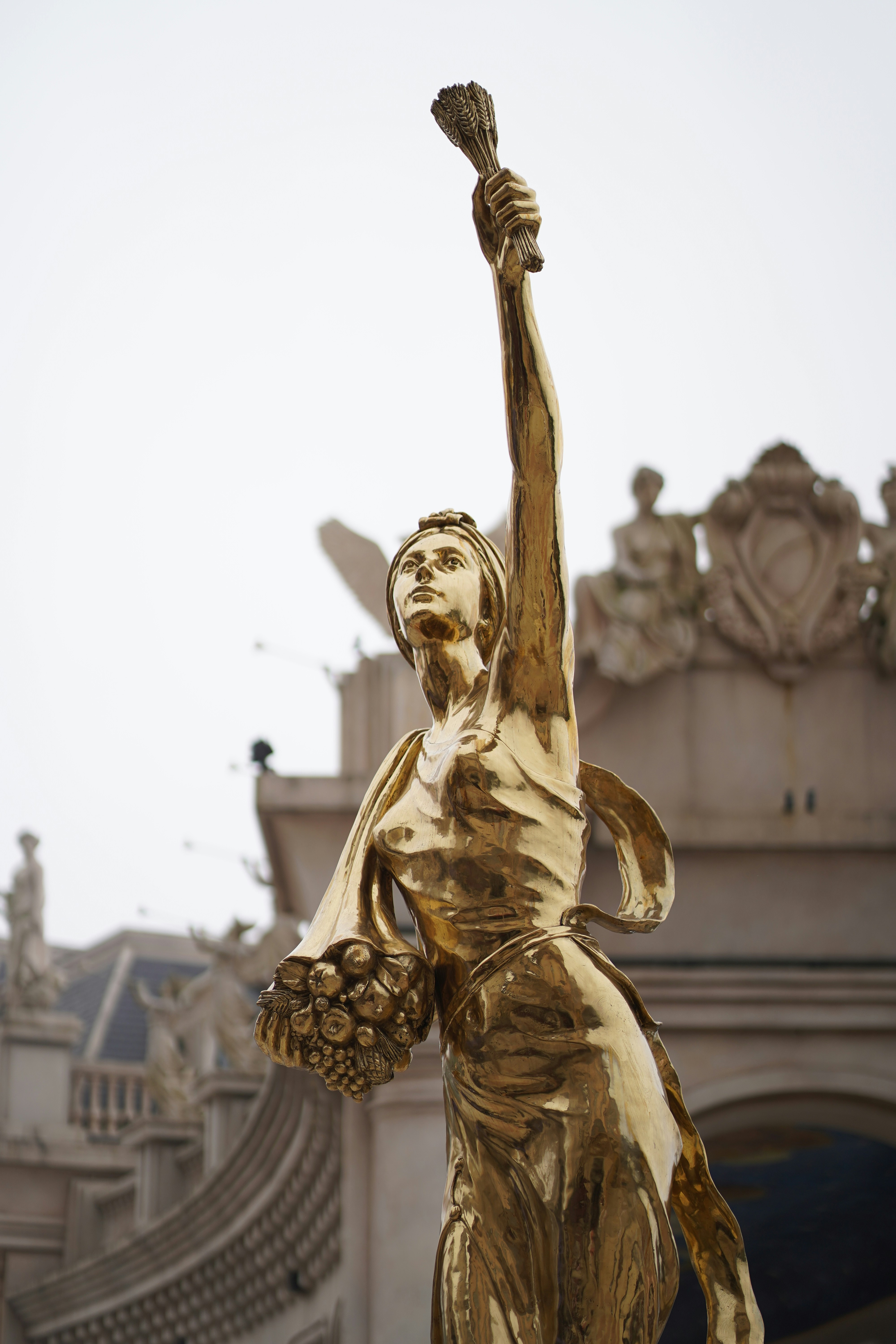 Gilded Torchbearer: Triumph Before Monumental Carvings