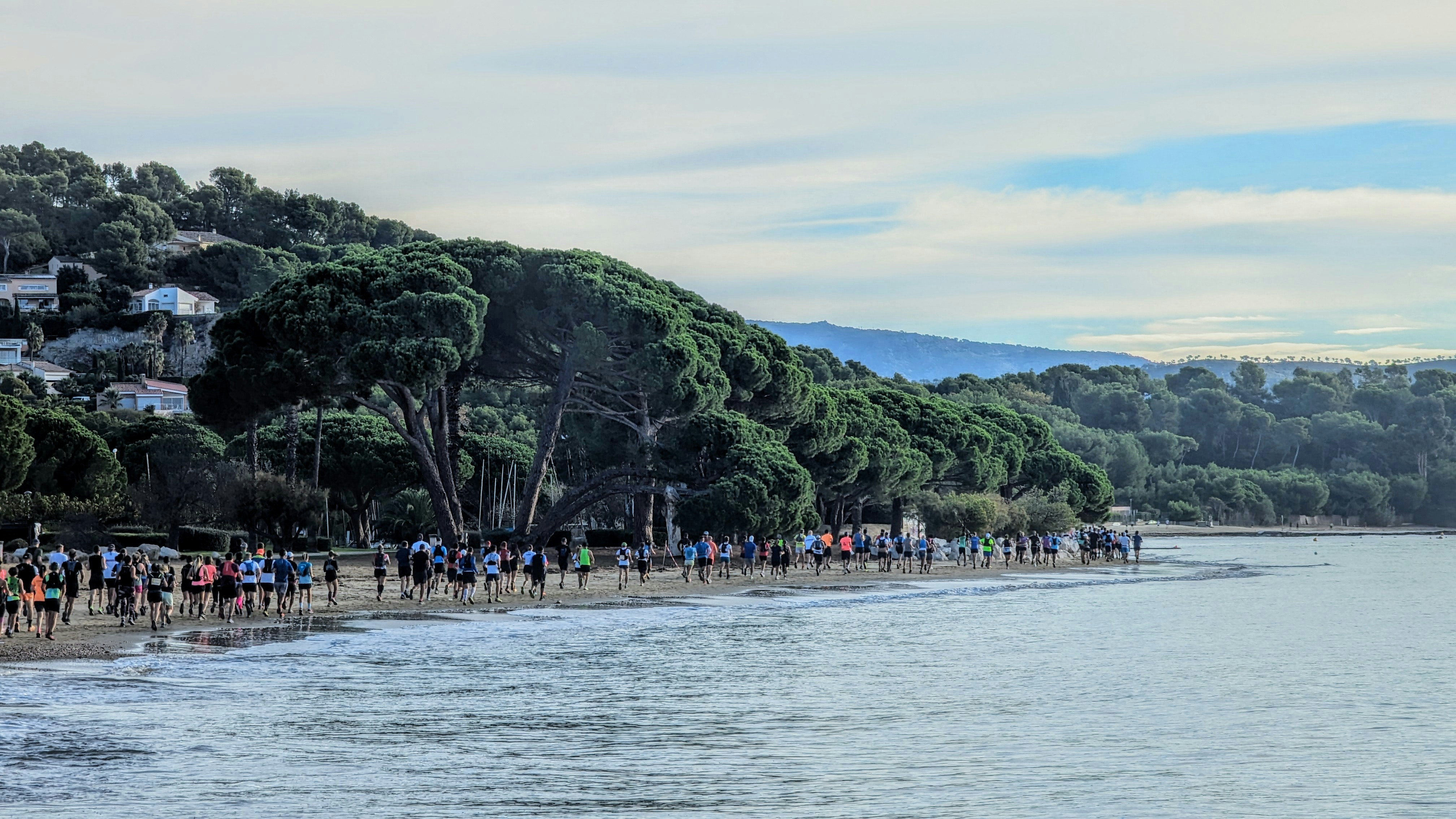 A group of people standing on a beach next to the ocean photo – Free La ...