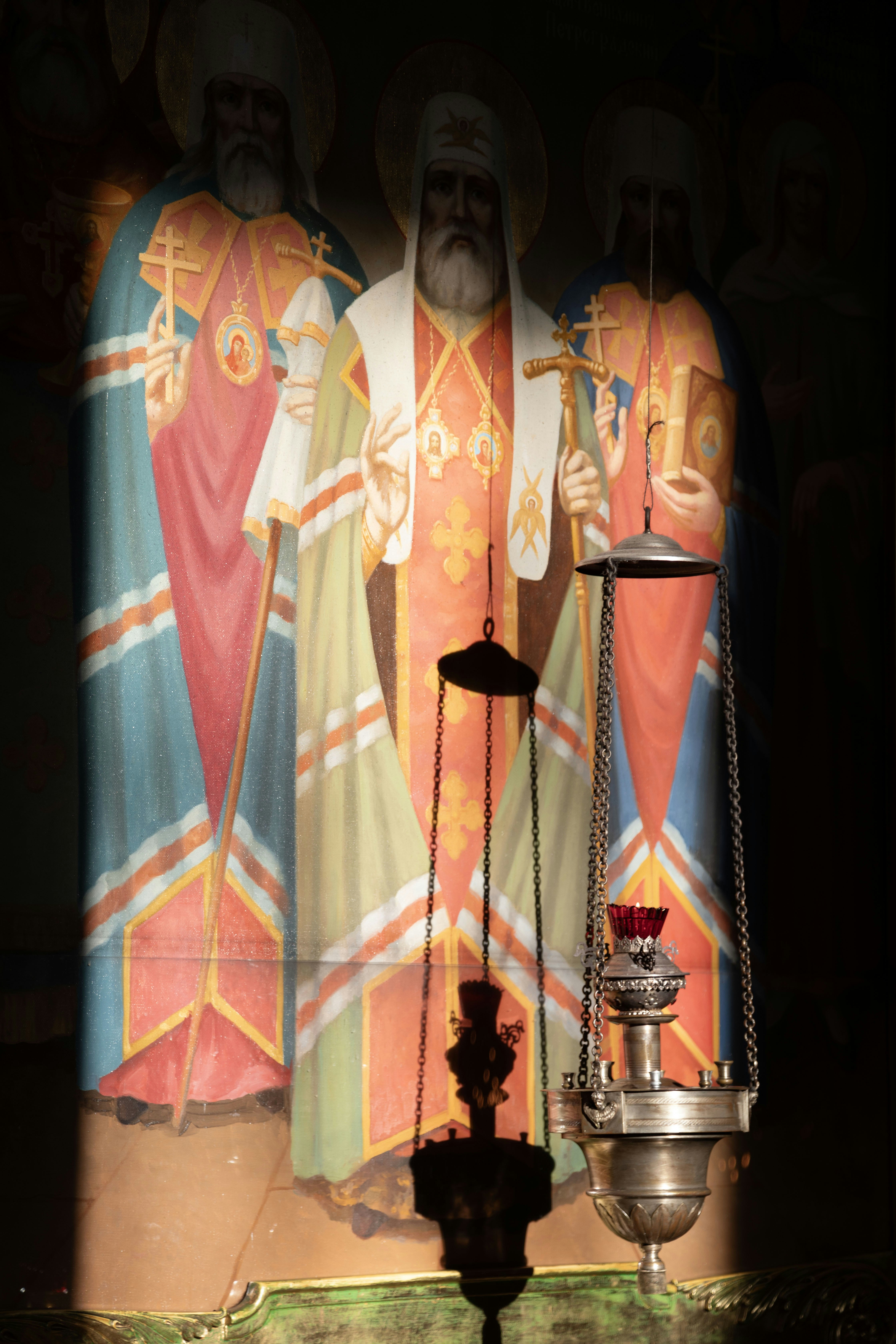 A statue of a priest in front of a stained glass window photo – Free ...