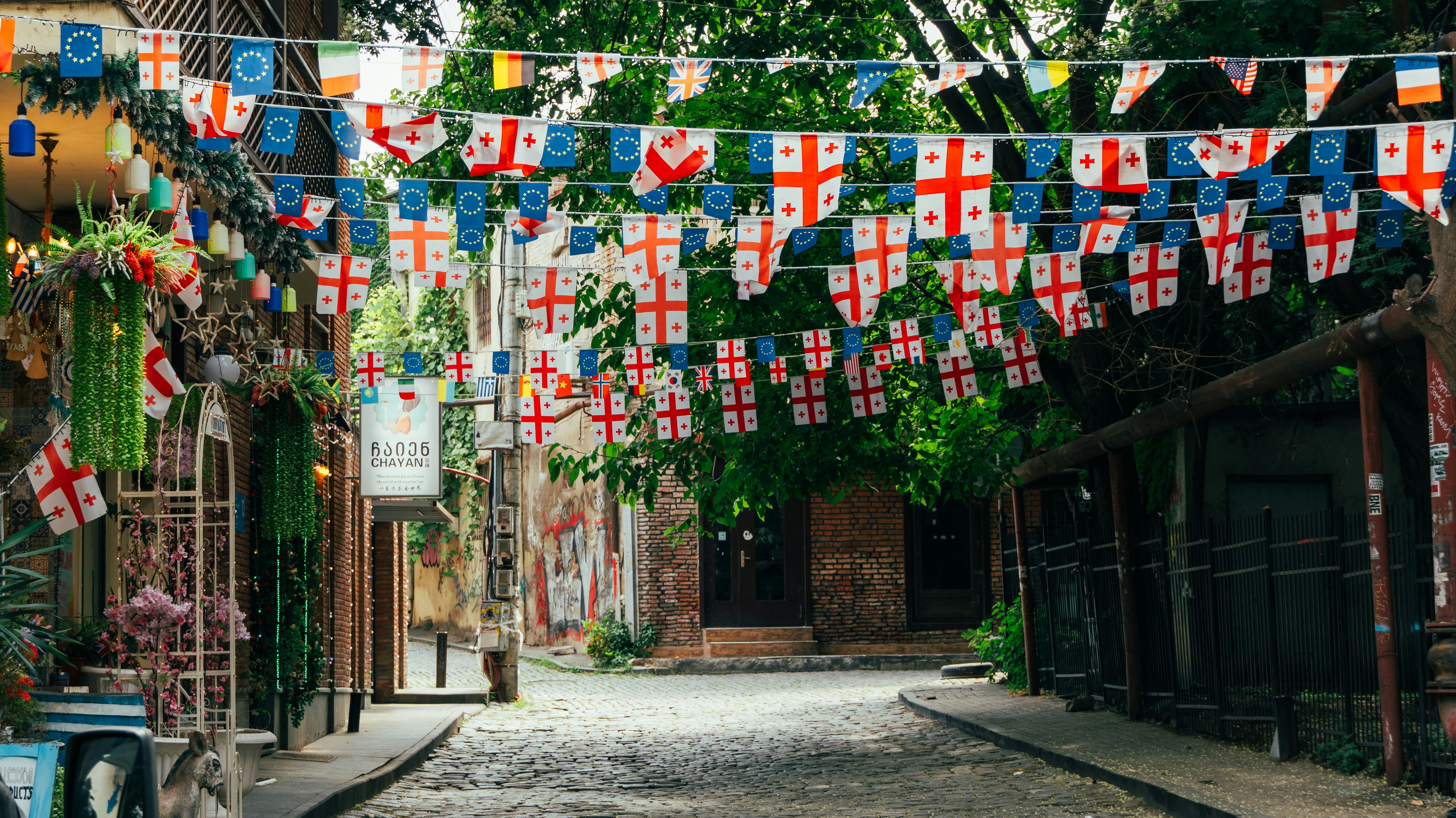 A narrow street with a lot of flags hanging from it's sides photo ...