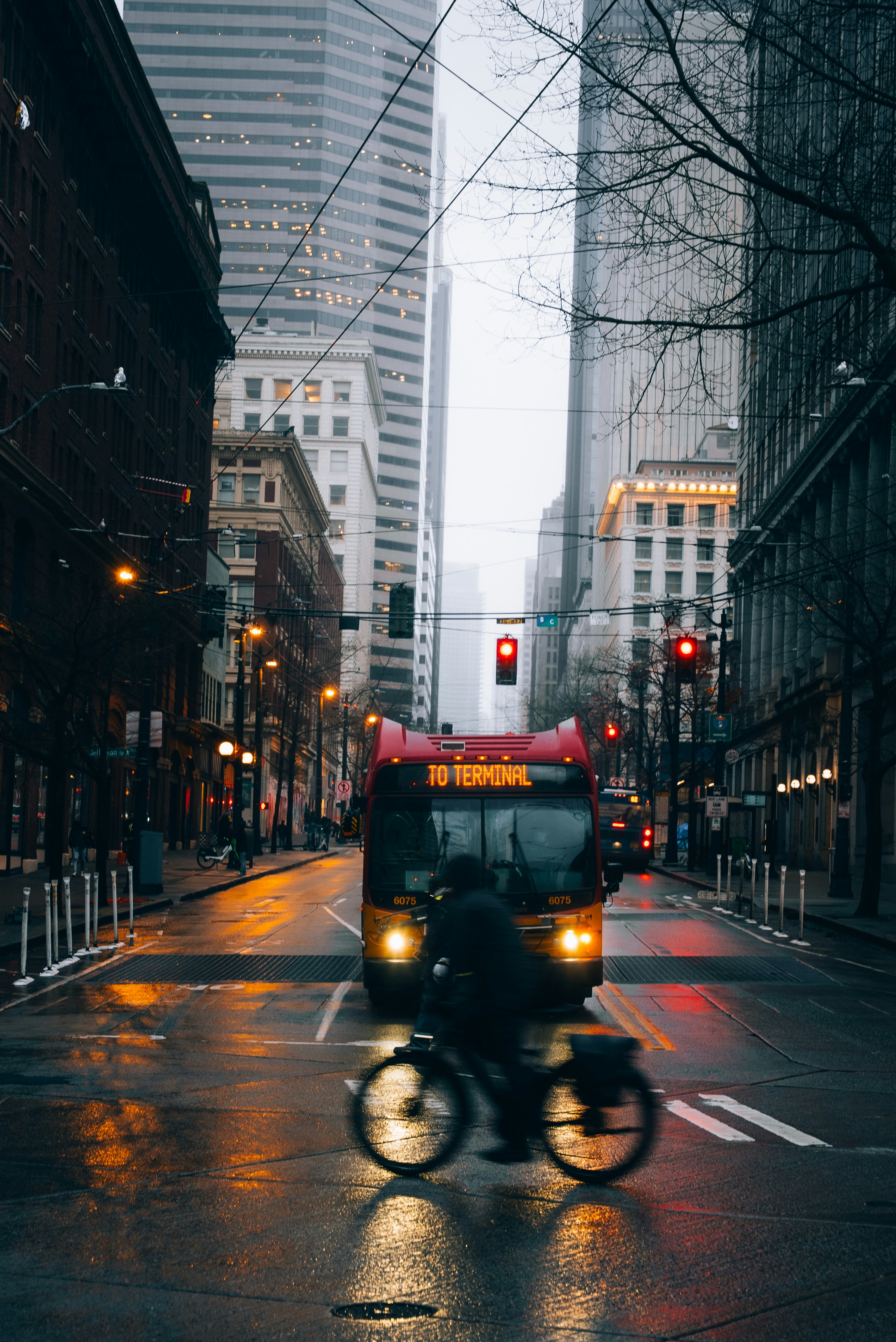 A bus driving down a street next to tall buildings photo – Free Seattle ...