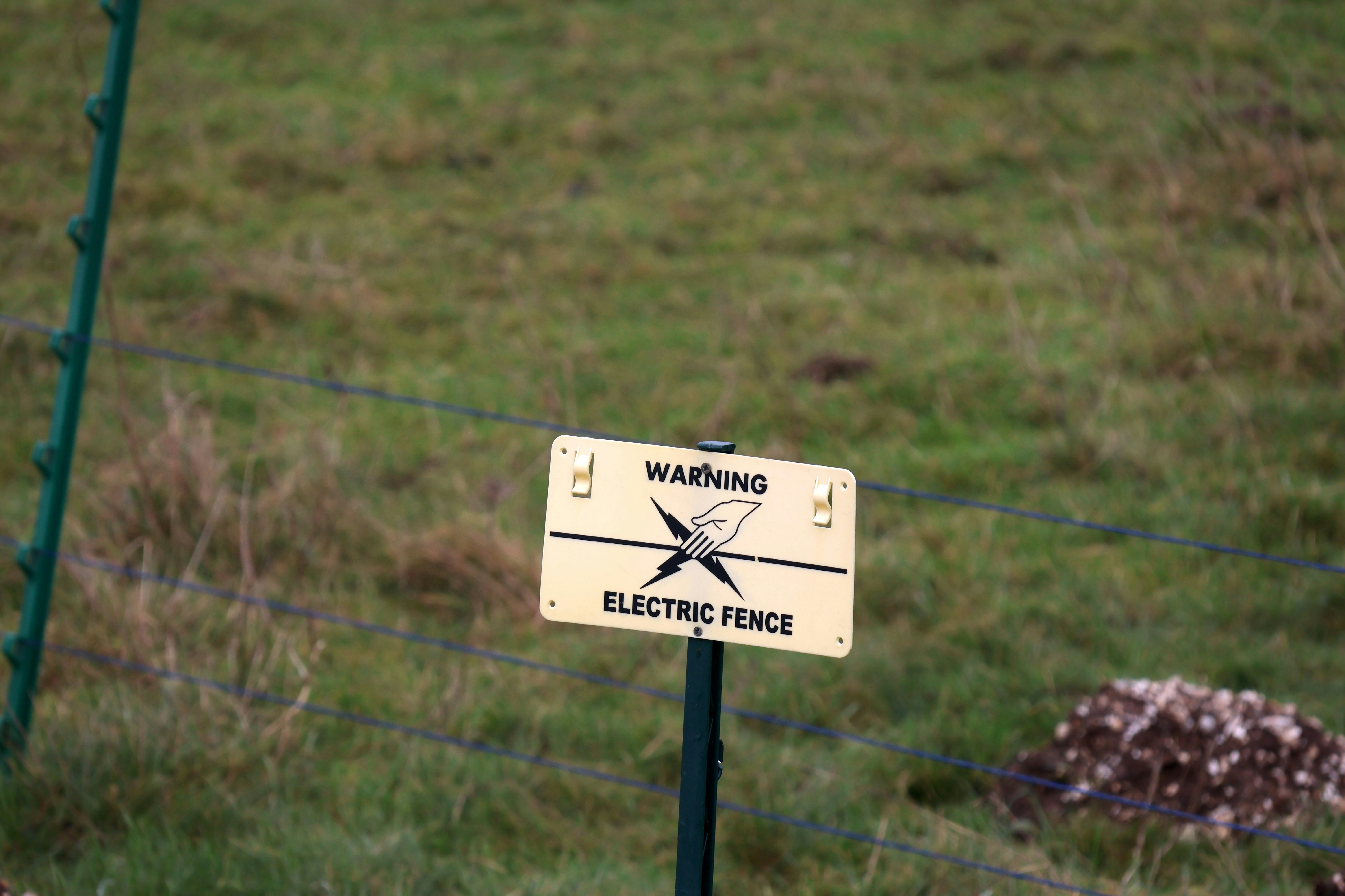 A sign on a post in front of a fence photo – Free Grass Image on Unsplash