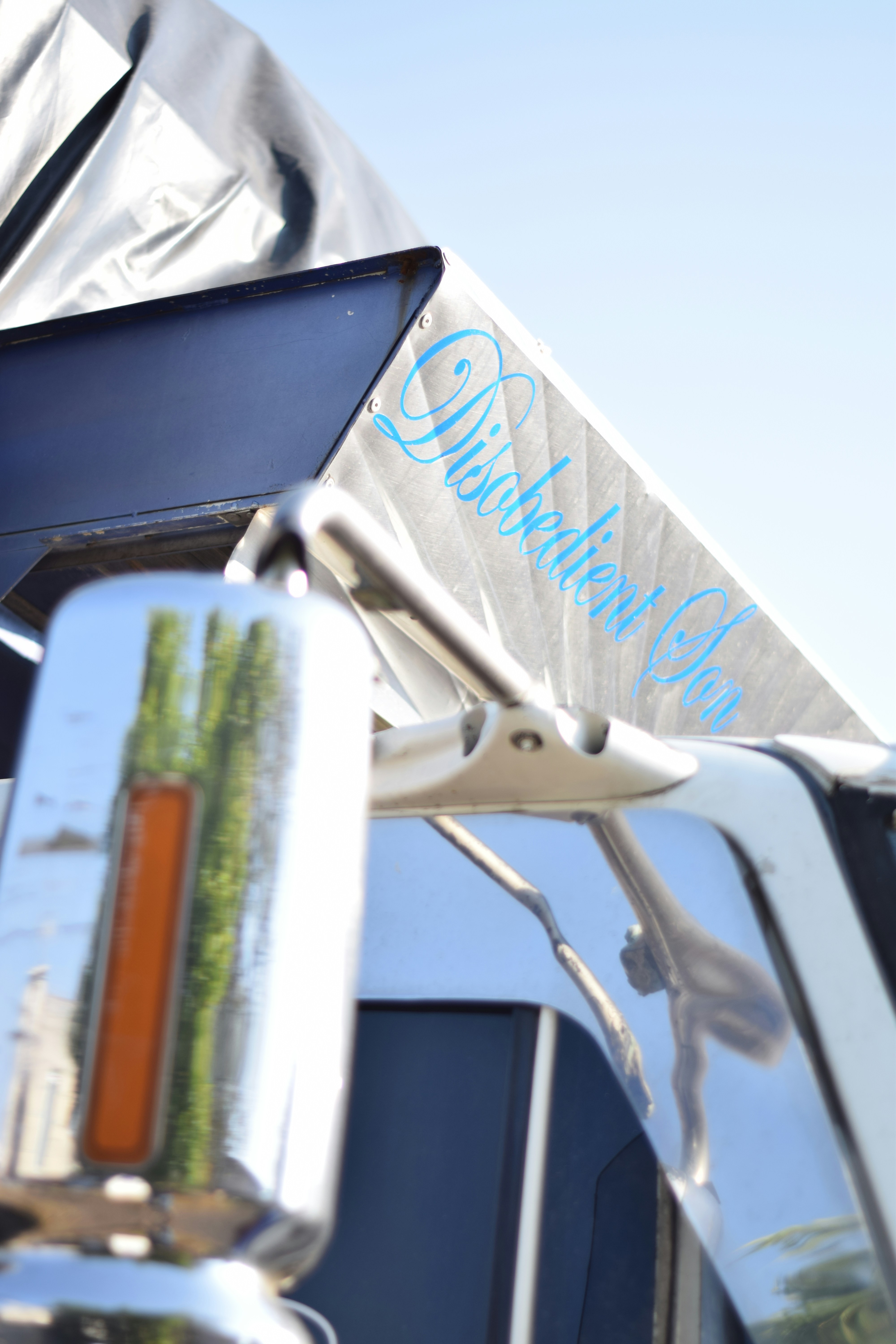 Chrome Mirror Portrait: Blue Script on a Weathered Truck