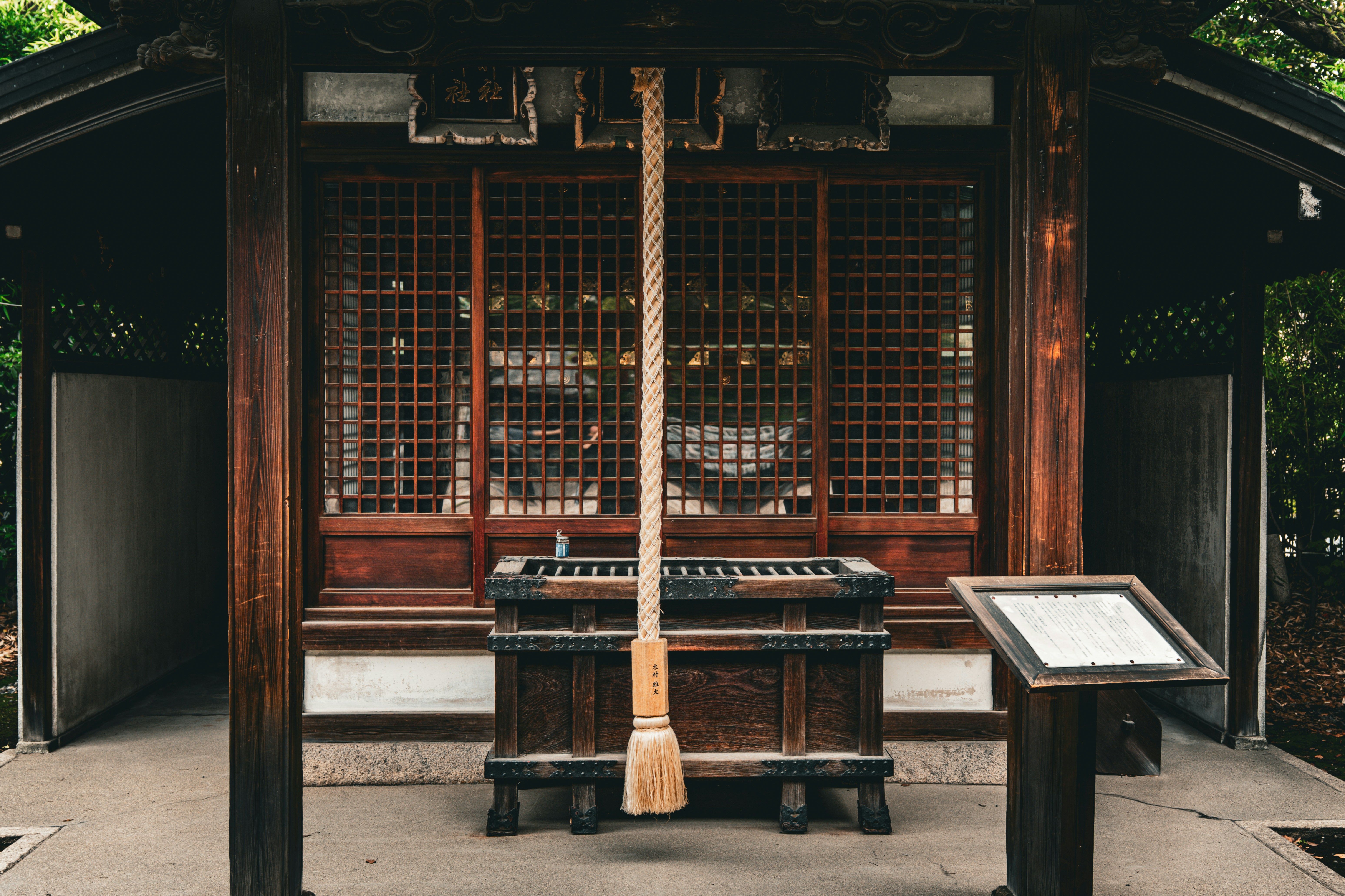Centered Shimenawa: A Quiet Shrine Framed by Lattice and Weathered Wood