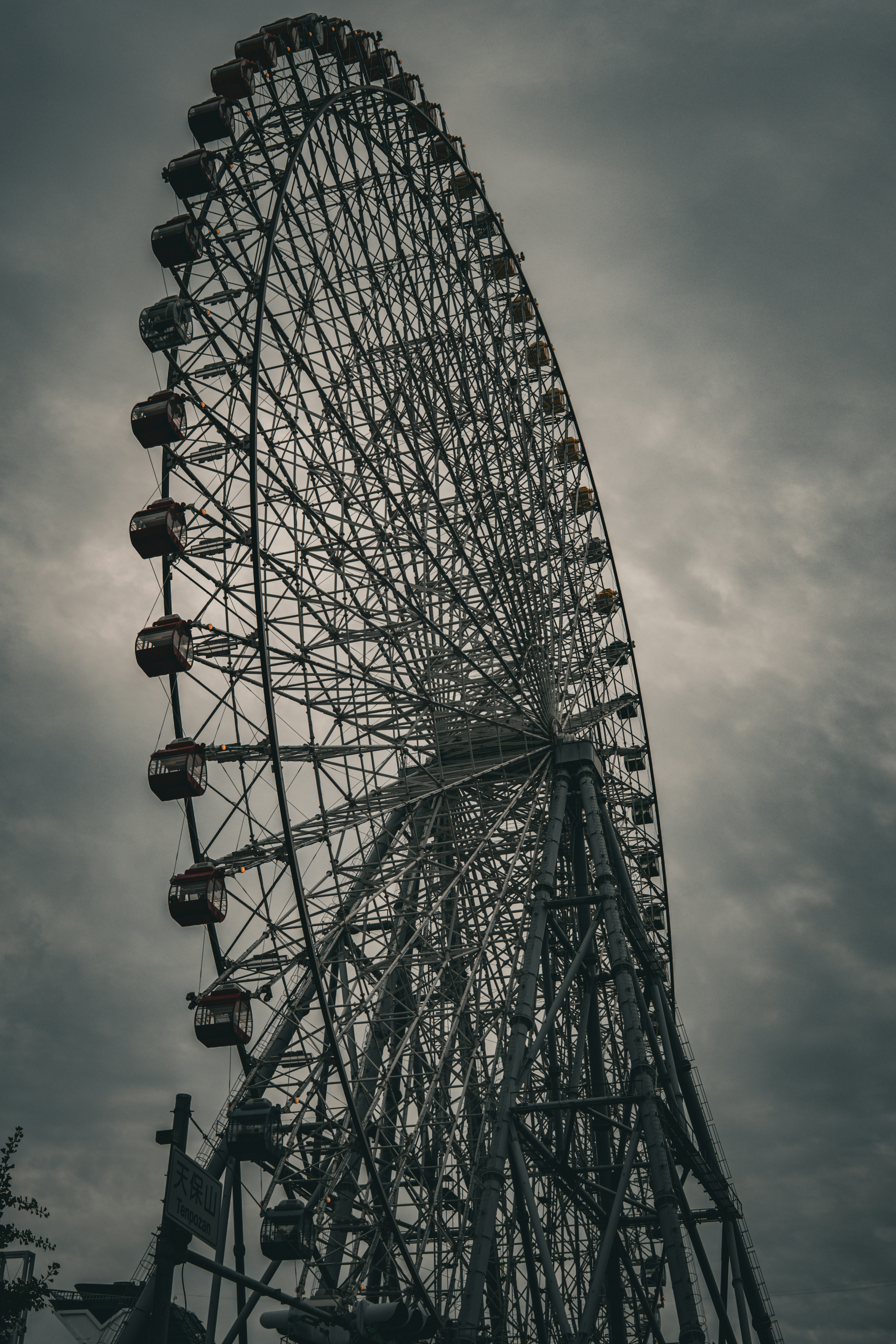 Iron Lattice Reaching the Clouds: A Weathered Ferris Wheel Amid Stormy Skies