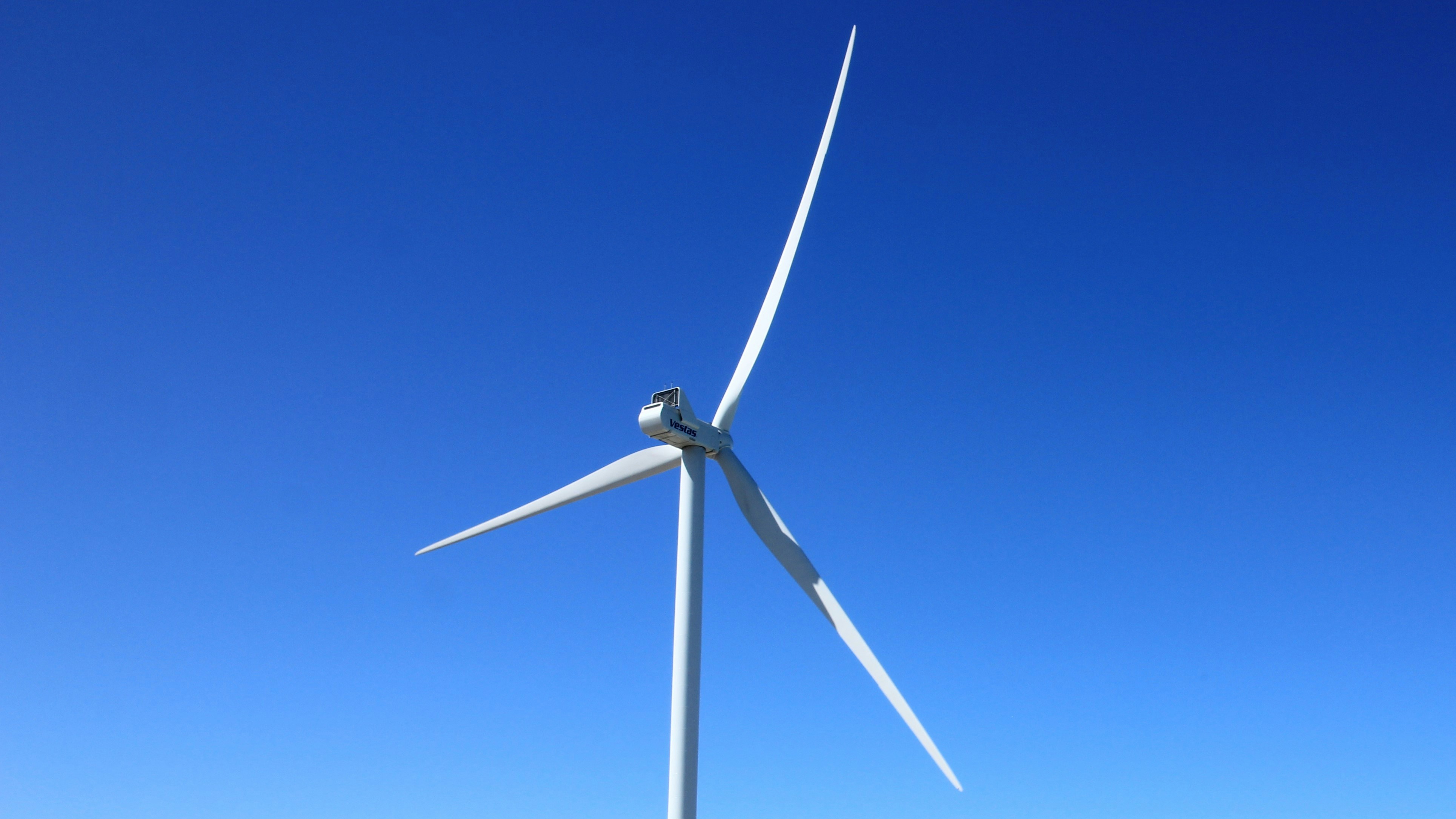 Majestic Wind Turbine Reaching Skyward Against a Pristine Blue