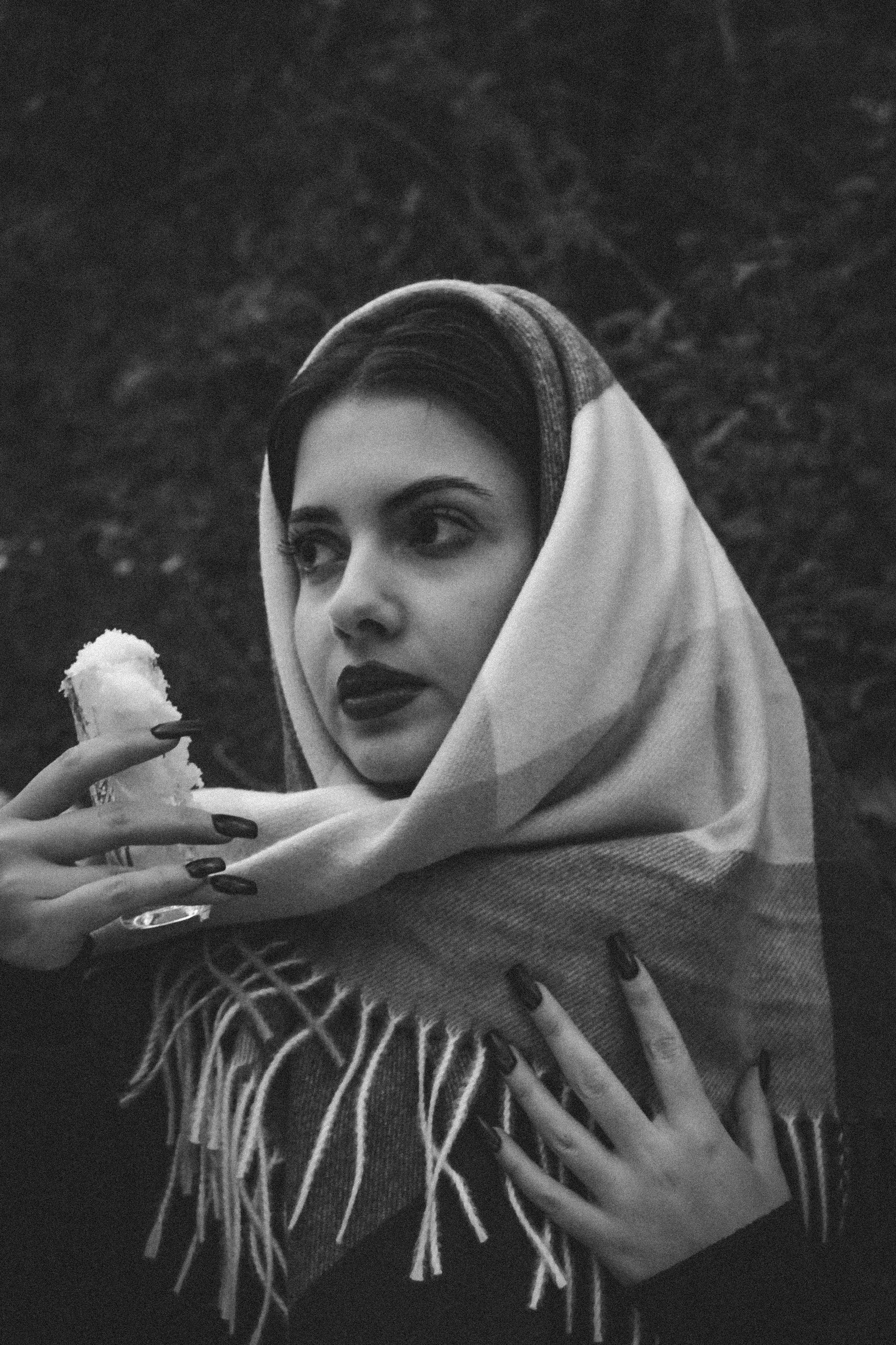 A woman with a scarf around her head eating a piece of cake photo ...