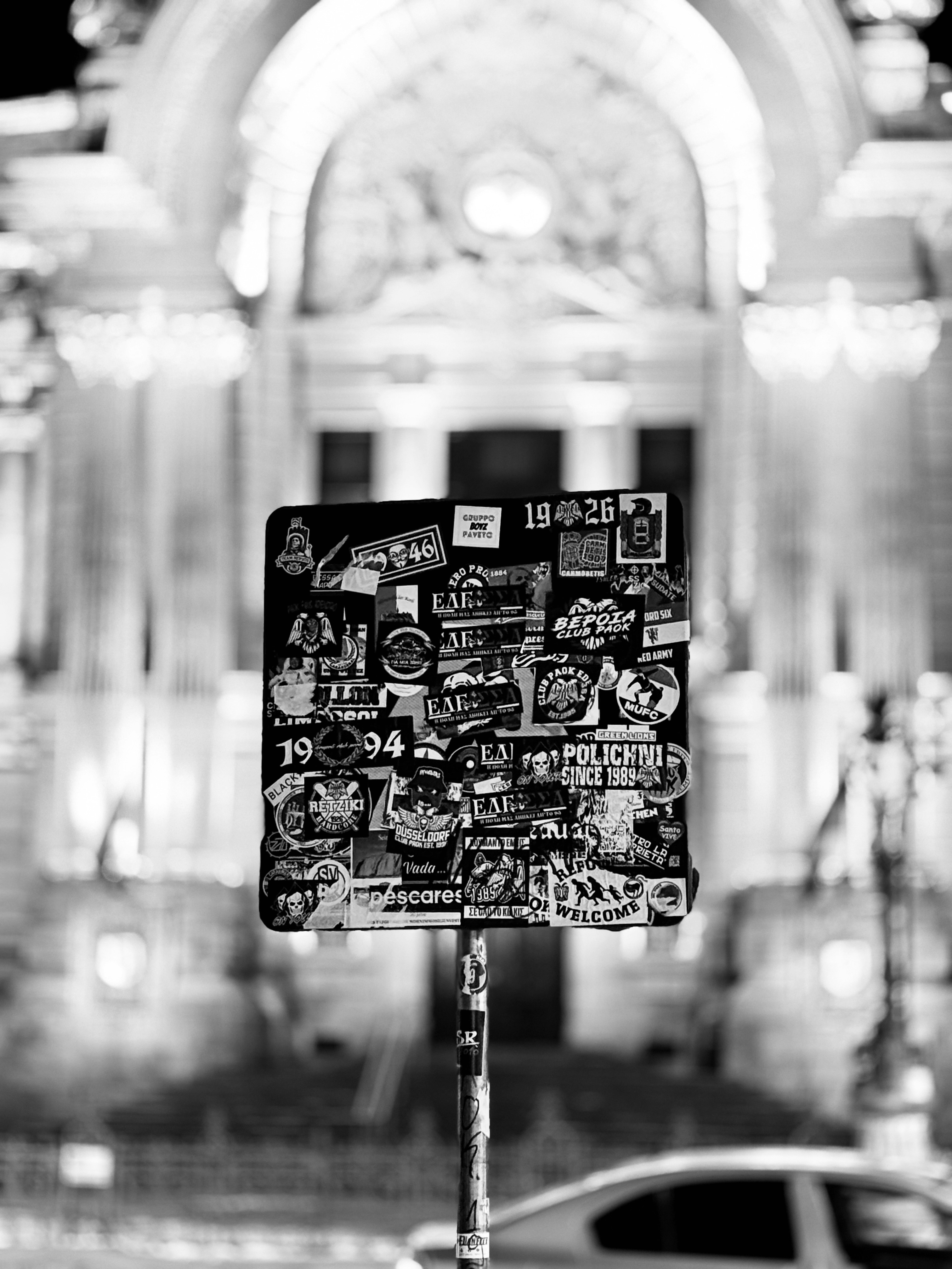 Stickered Sign in Front of Ornate Archway