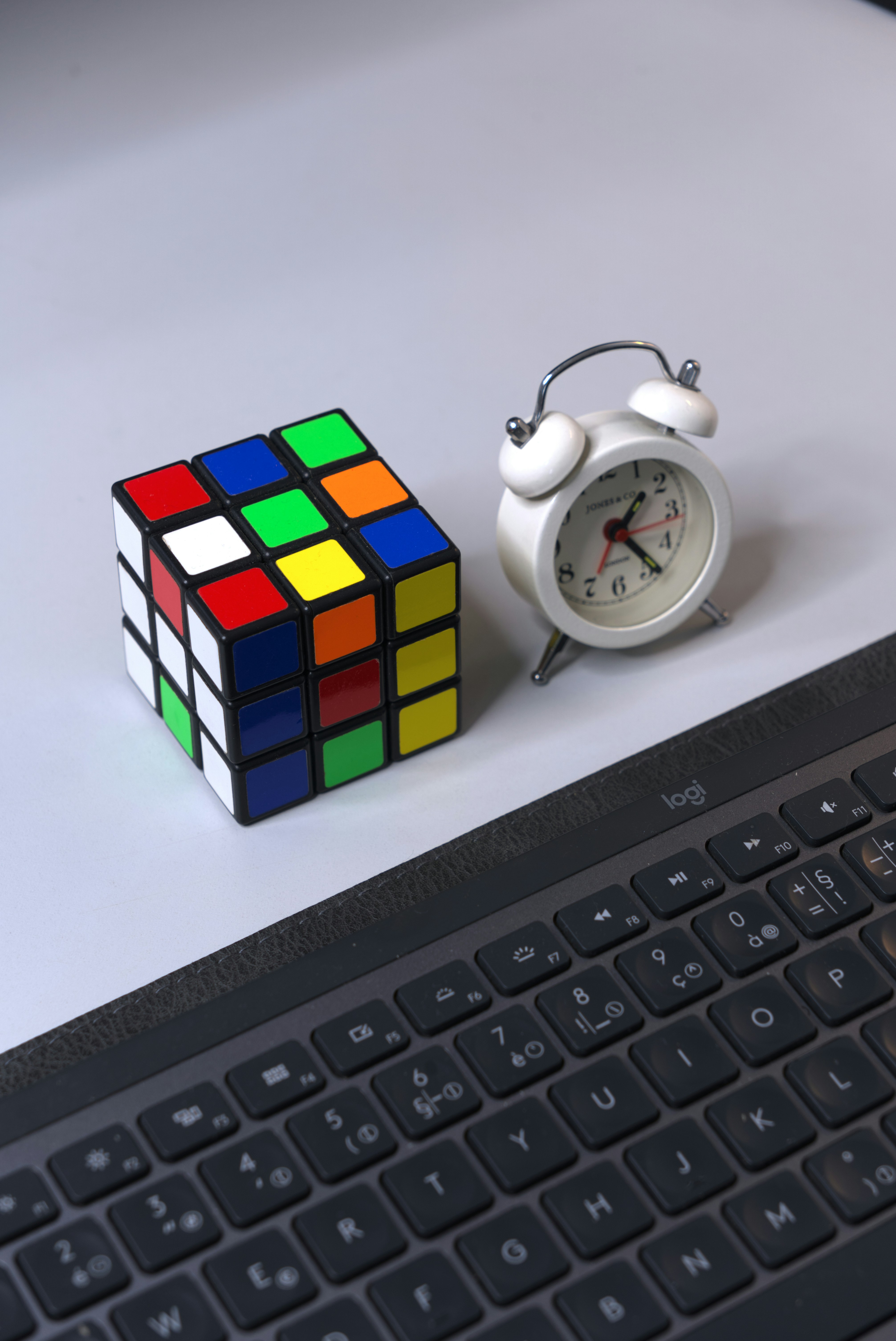 A rubik cube next to a clock on a keyboard photo – Free Computer Image ...