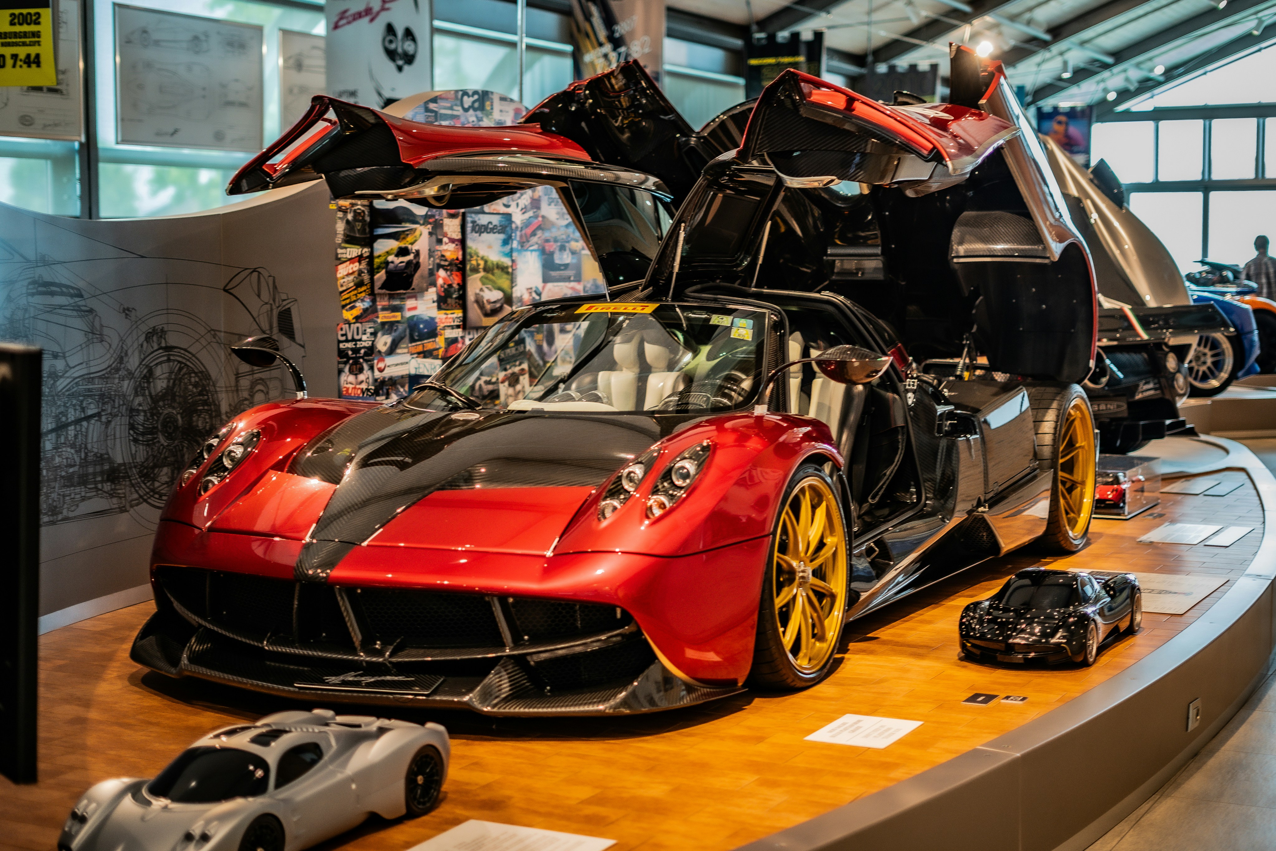 Luxury sports car with open gullwing doors displayed in an automotive museum.
