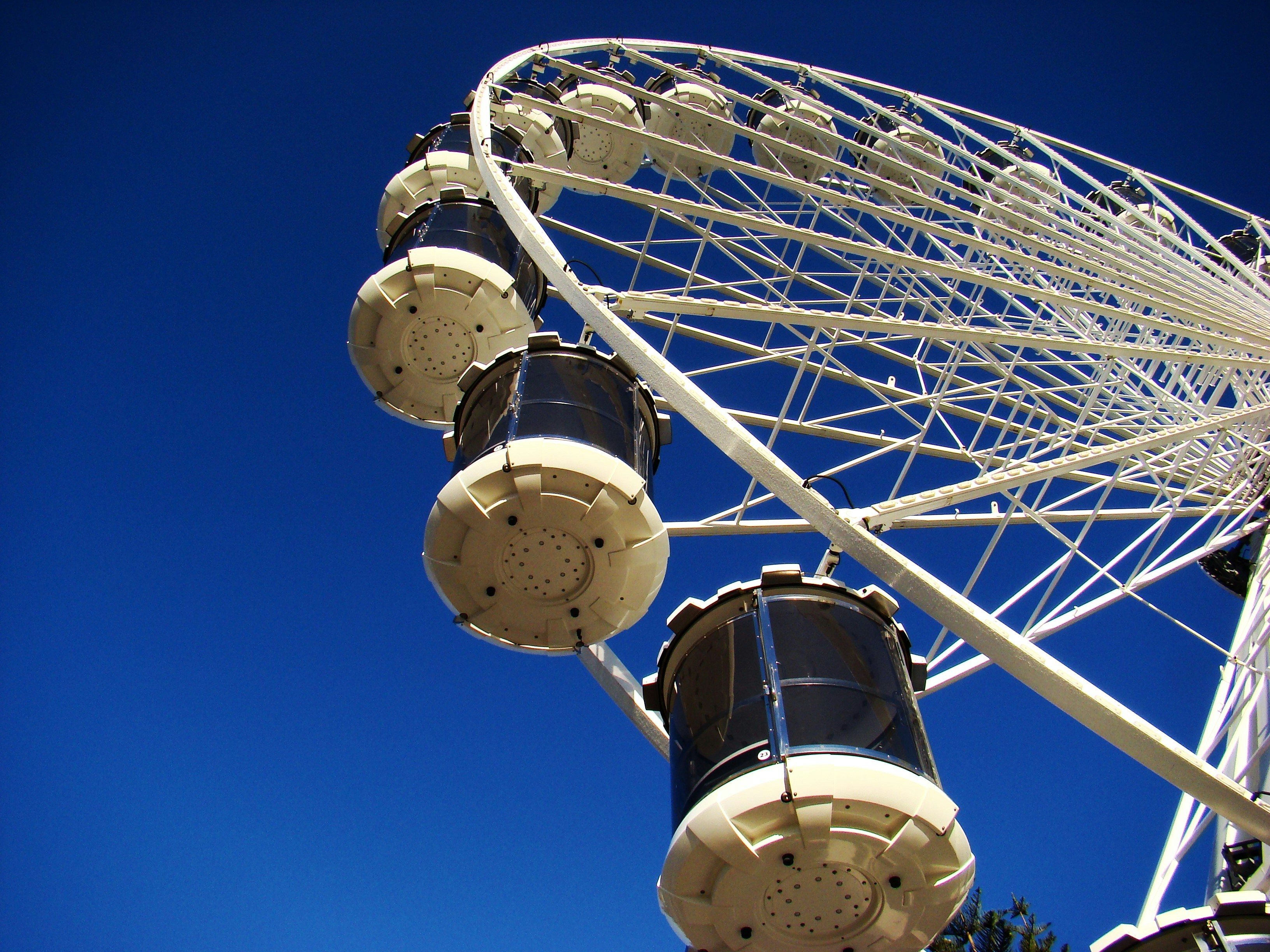 Ferris wheel cabins ascending against a vivid blue sky.