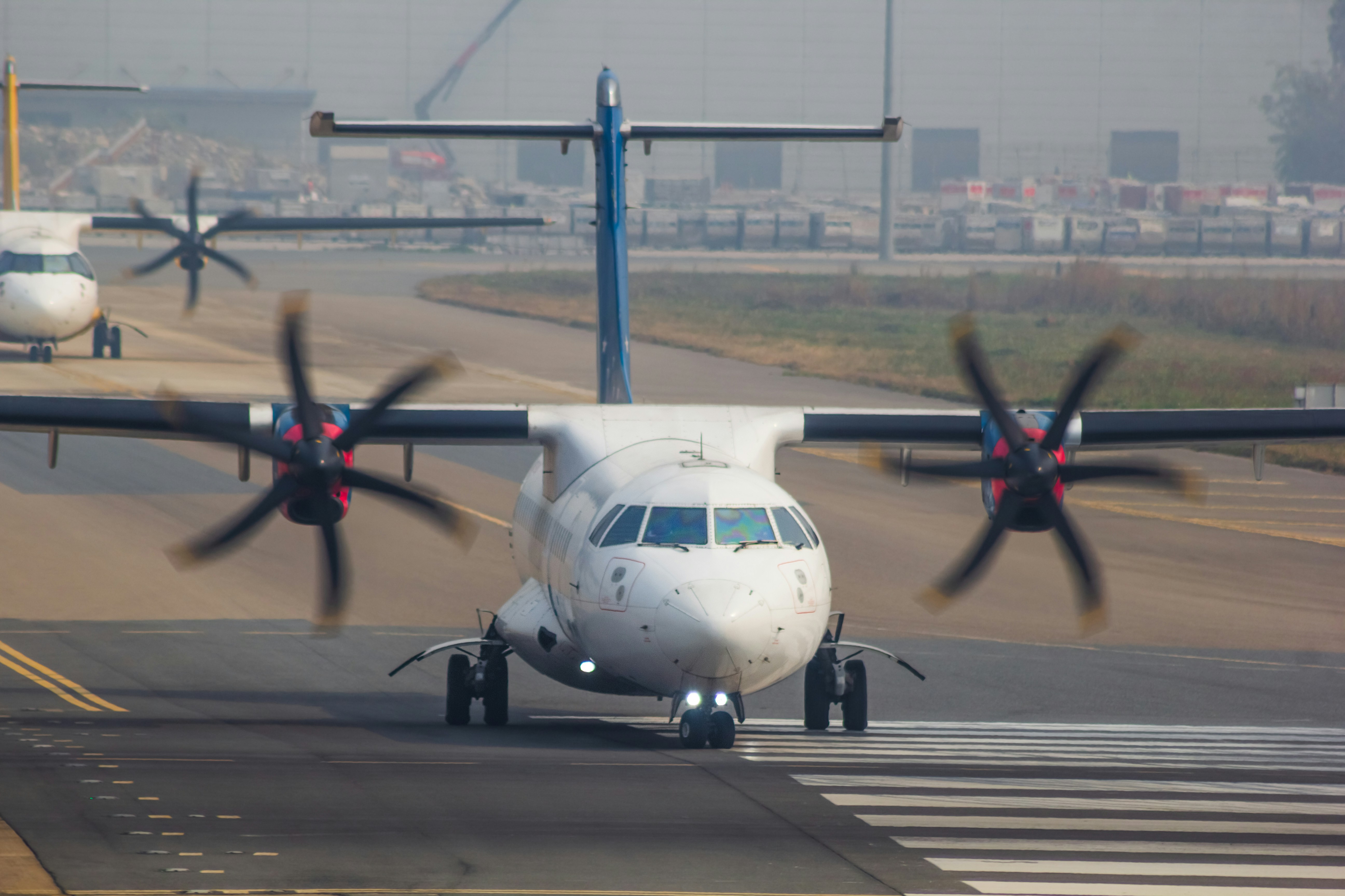 A large propeller plane sitting on top of an airport runway photo ...