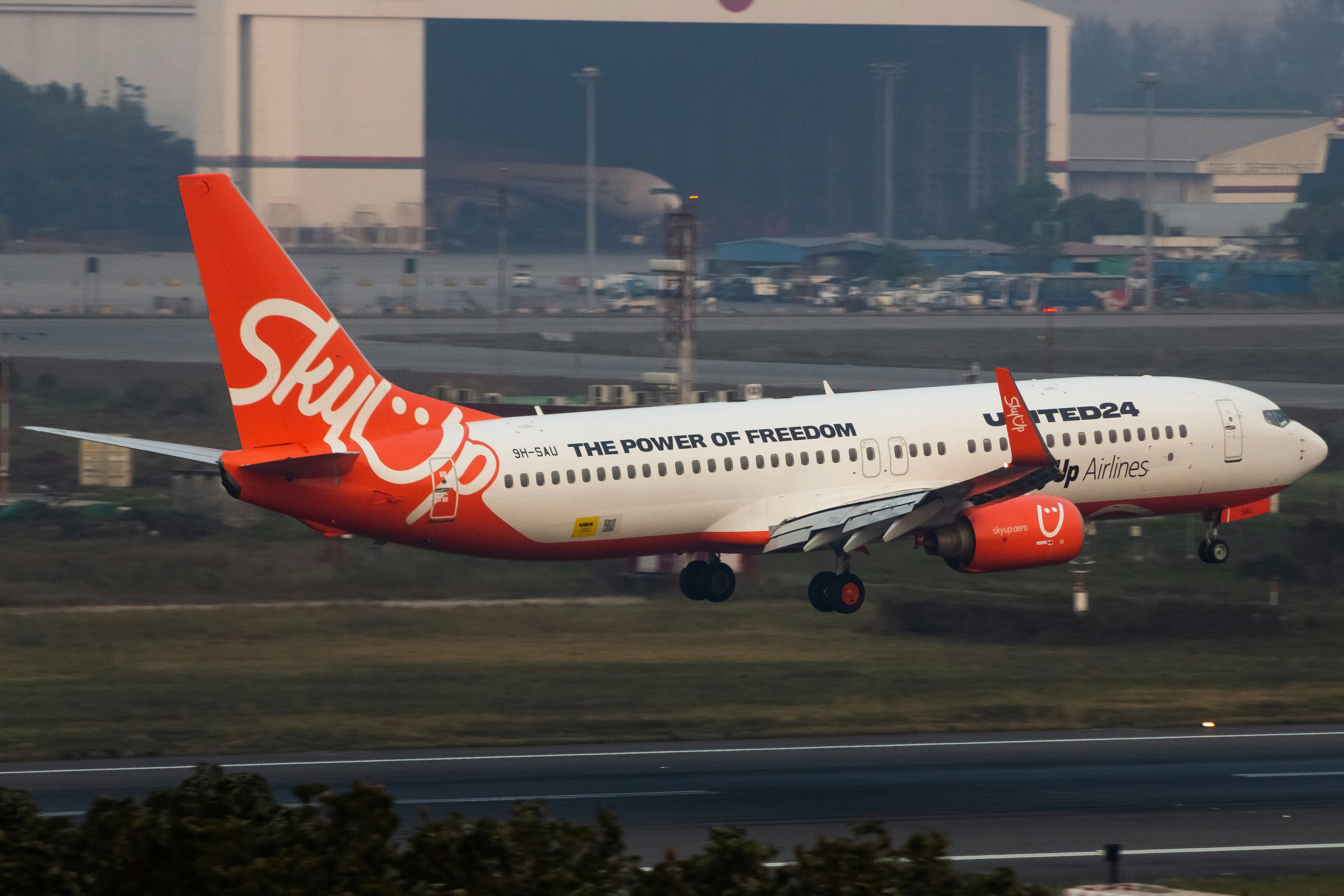 A red and white jet airliner taking off from an airport runway photo ...
