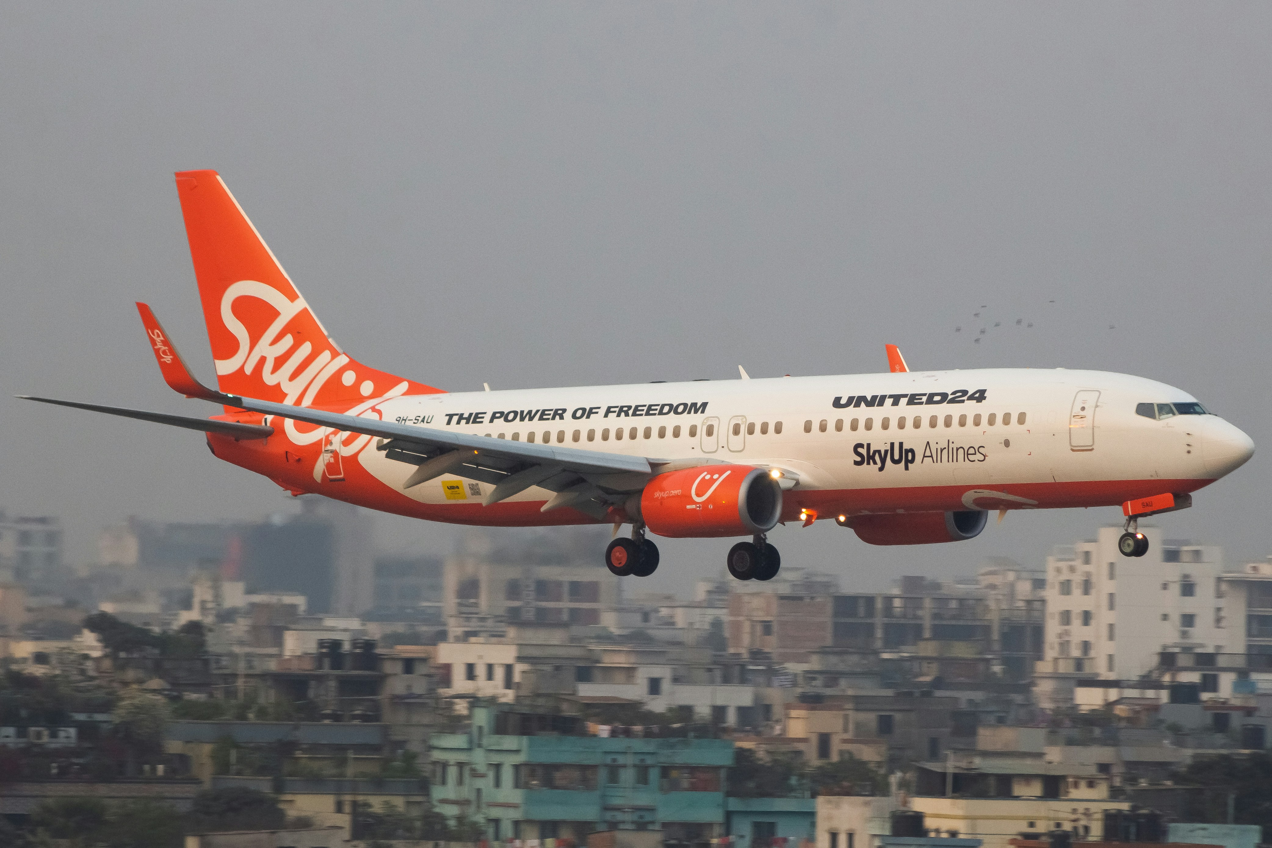 SkyWide: A UnitedJet airliner gliding over a dense cityscape