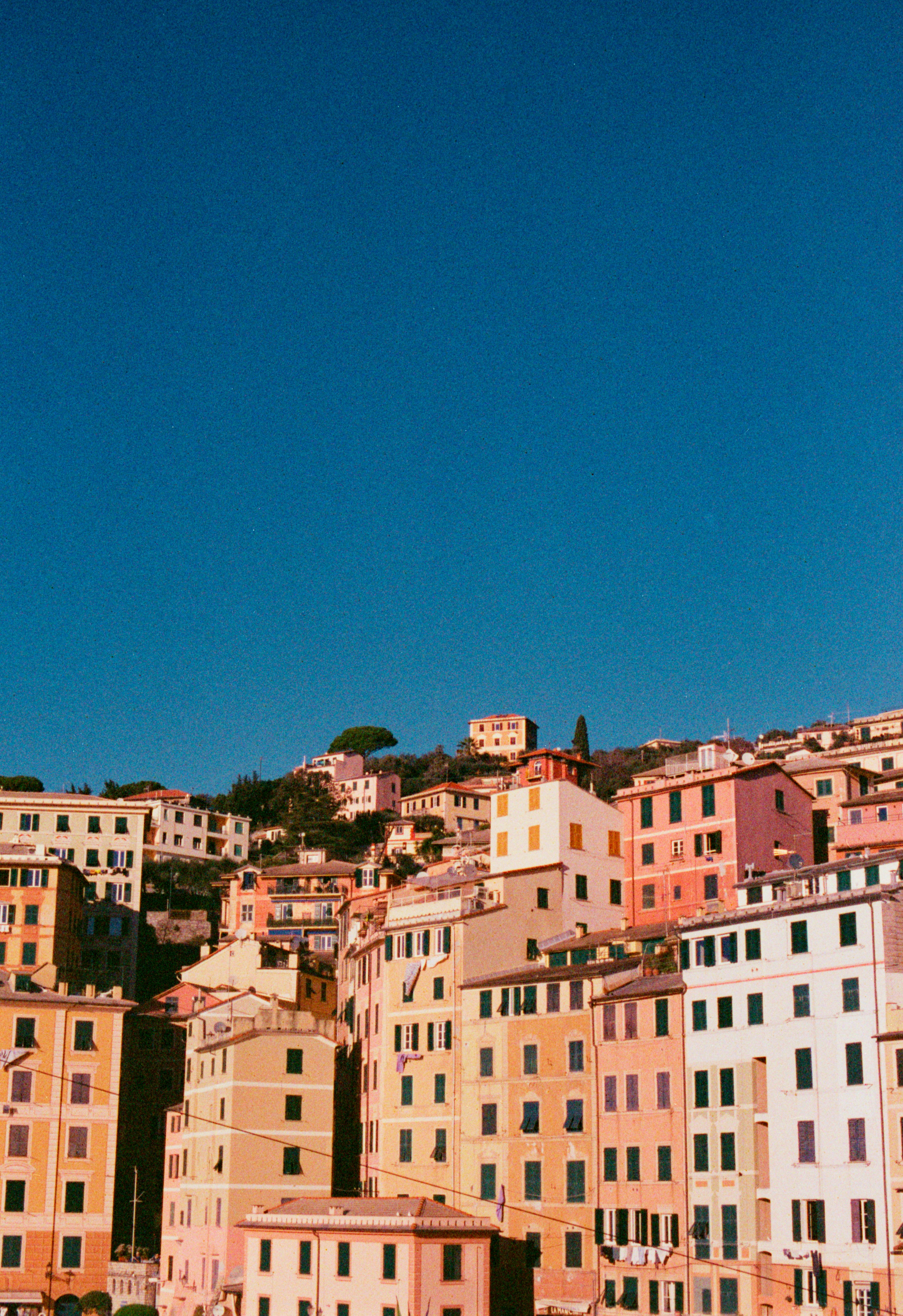 Sunlit Italian hillside: pastel houses cascade into a Mediterranean town