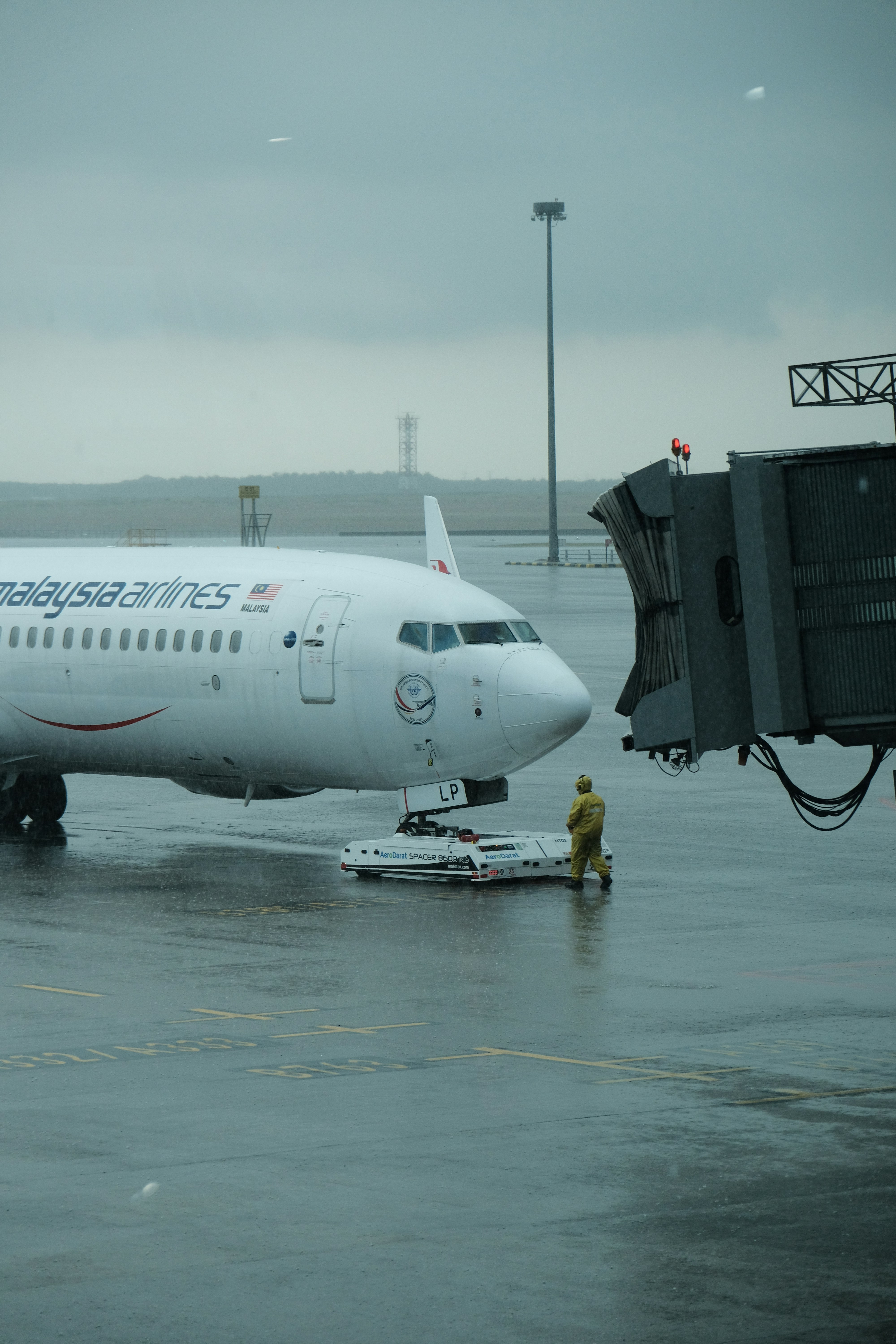 Dockside Journey: A Malaysia Airlines A321 at the Gate in Rain