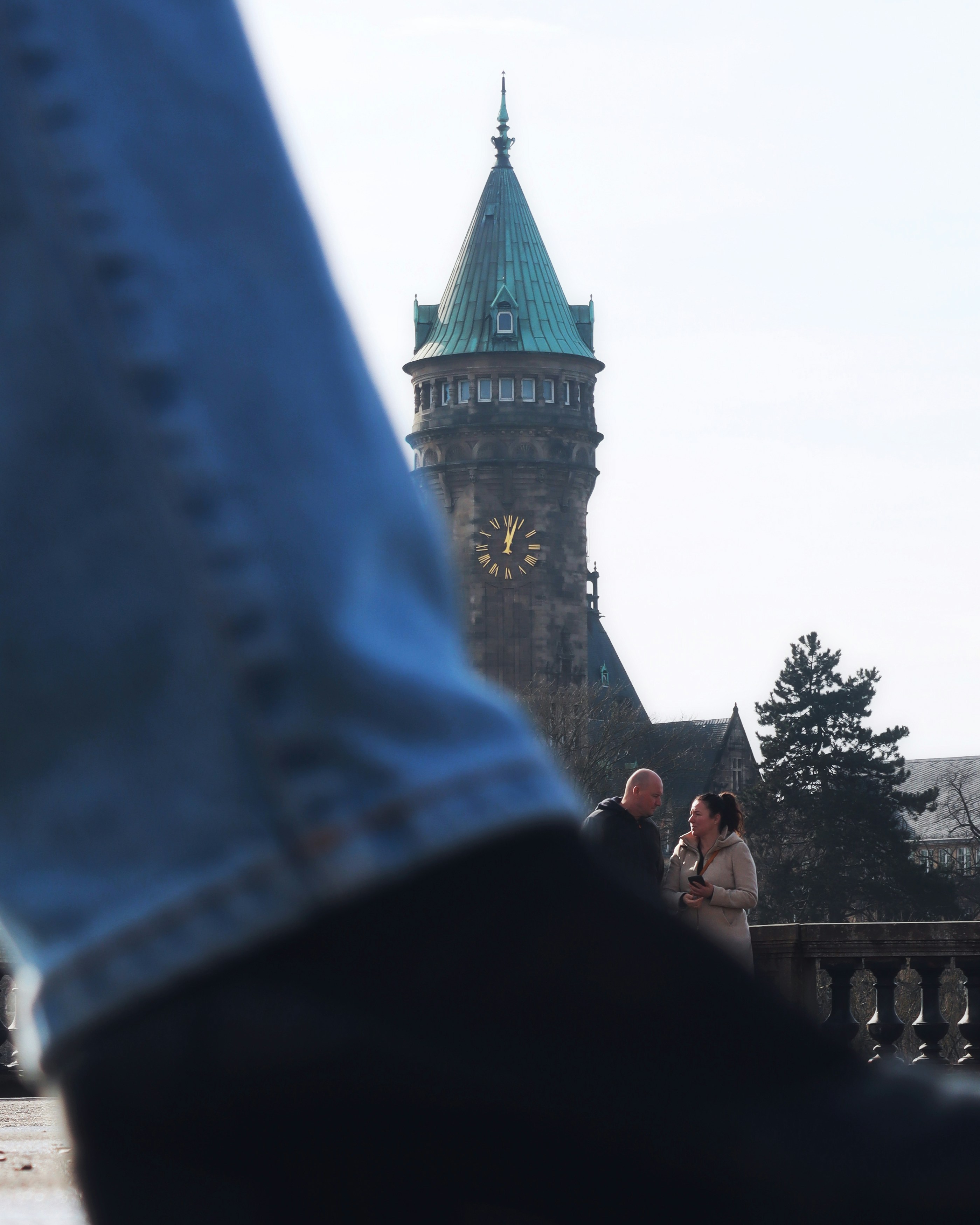 Towered Quiet: A City Moment Framed by Foreground Blur