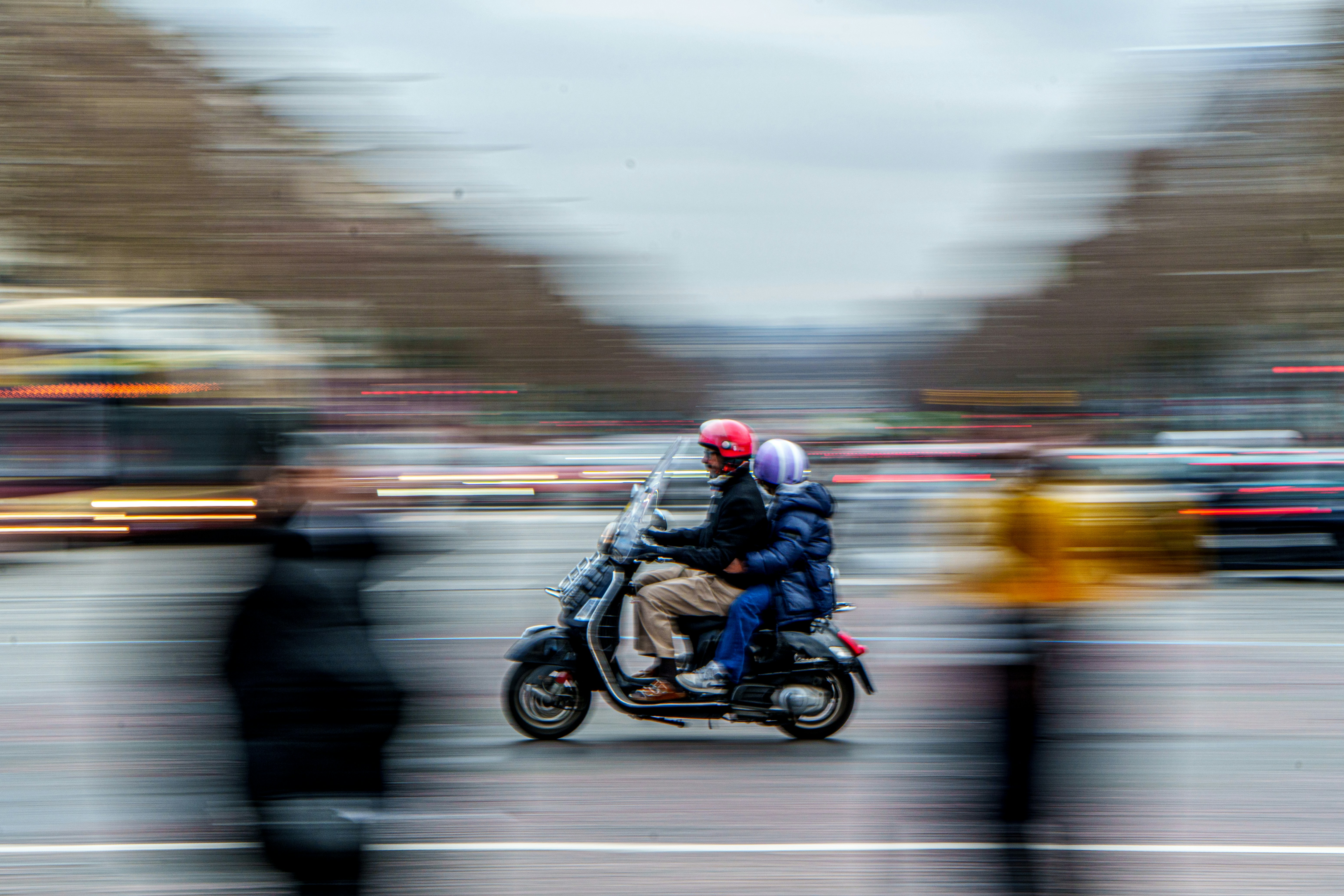 Urban Motion: Two Riders Glide Through a City Blur on a Scooter