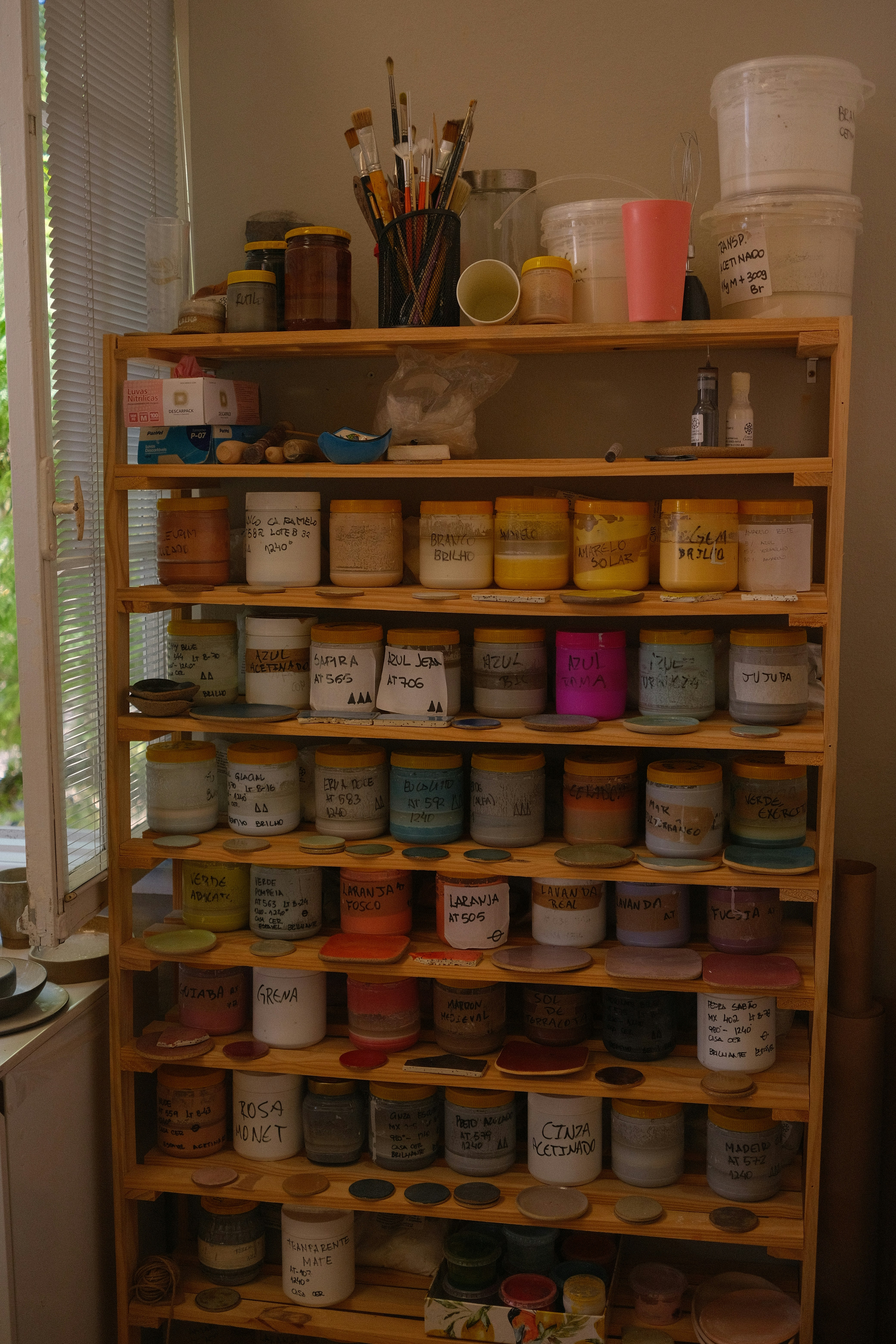 Shelves of Colorful Paint Jars: Organized Chaos in an Art Studio