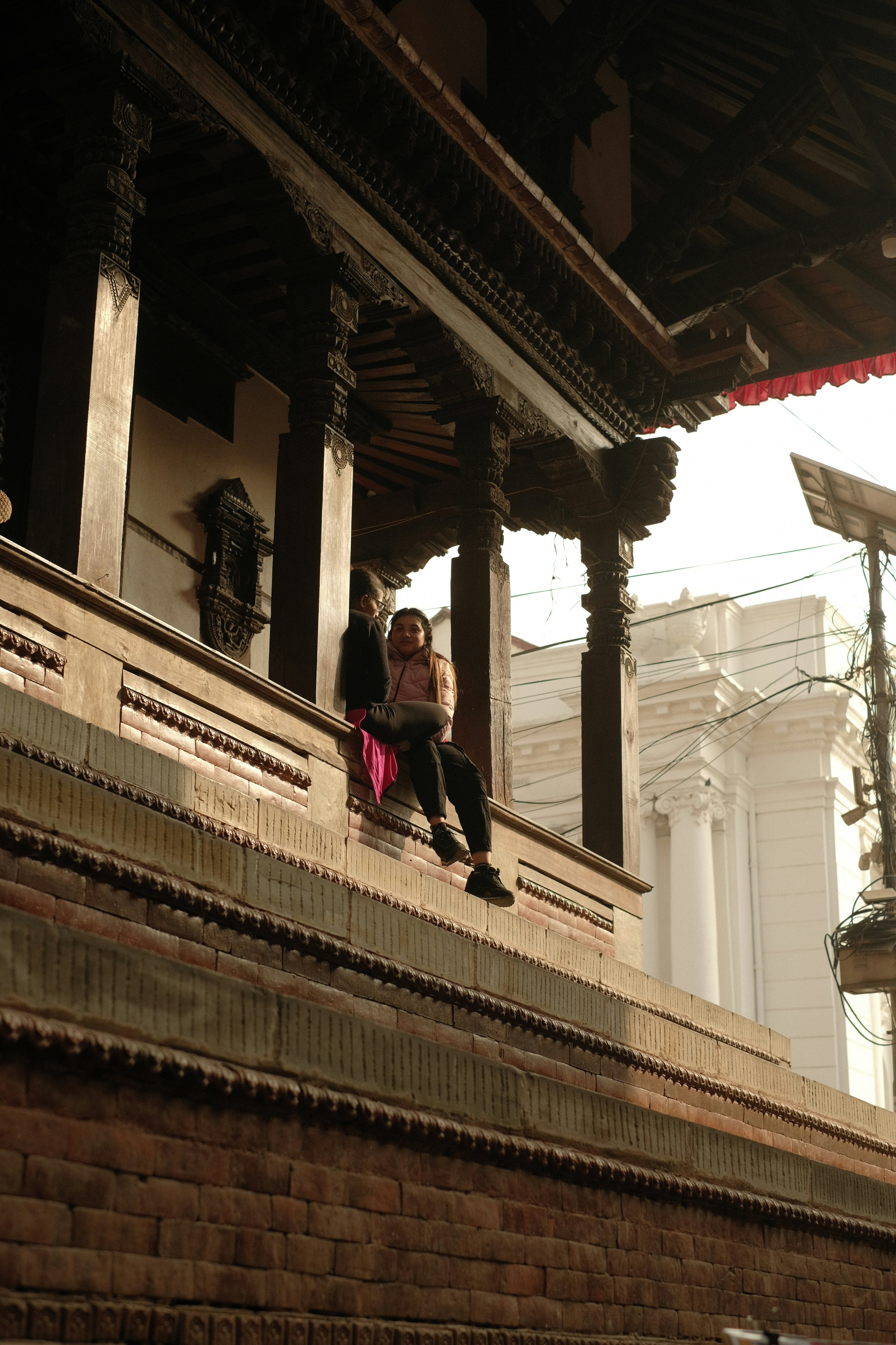 Balcony Quiet: A Moment Between Two Figures in a Historic Verandah