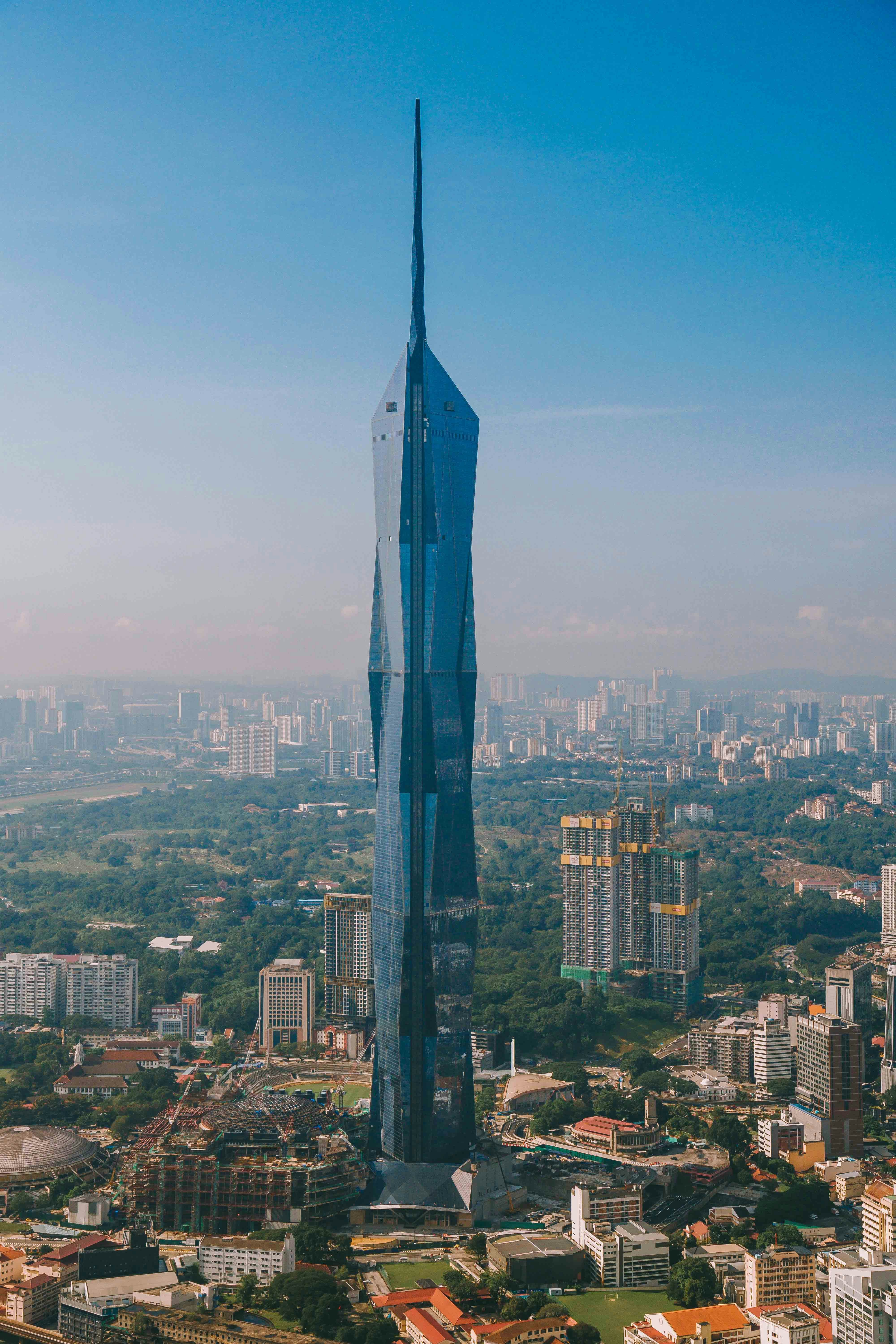 A very tall building towering over a city photo – Free Kuala lumpur ...