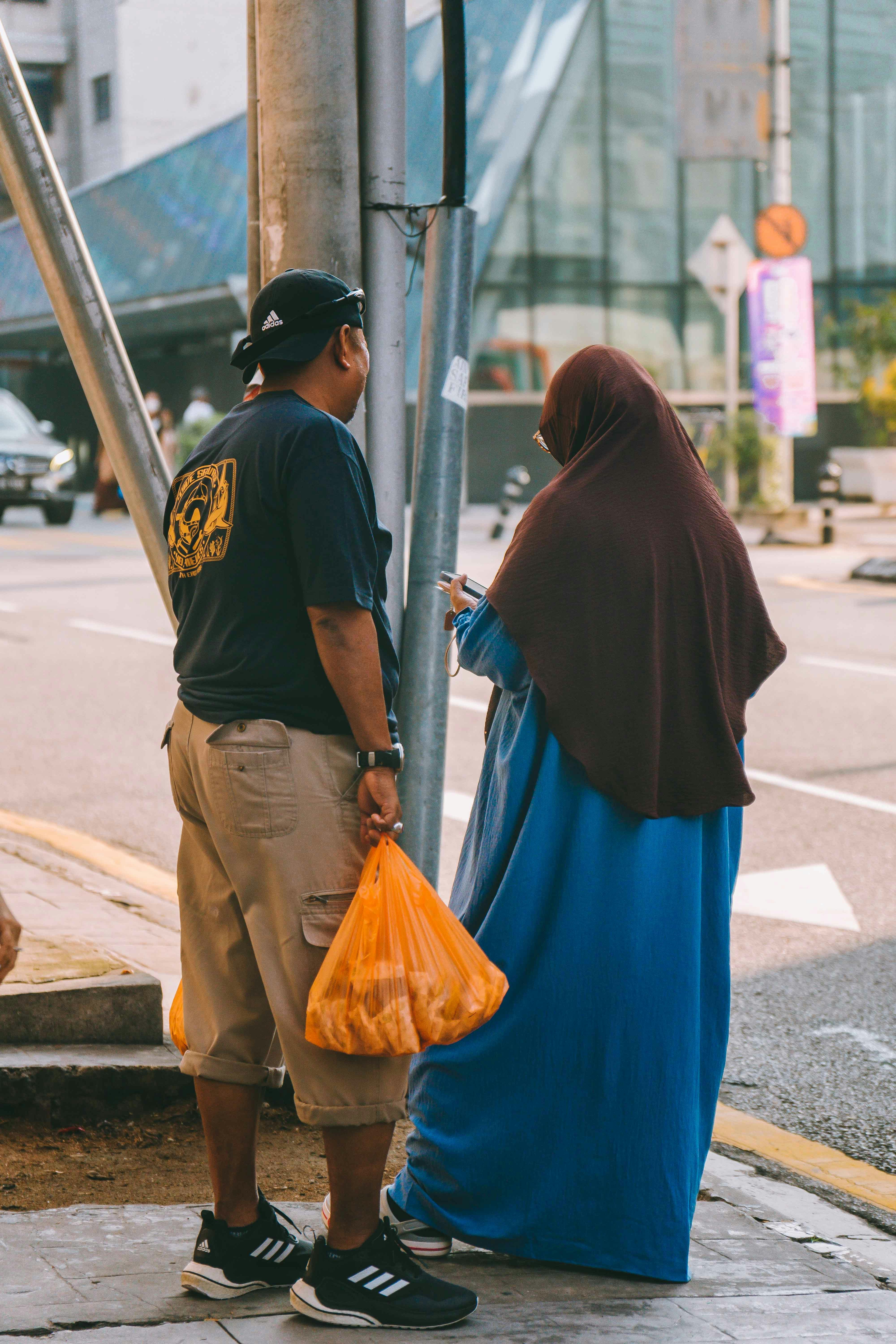 A man and a woman standing on a street corner
