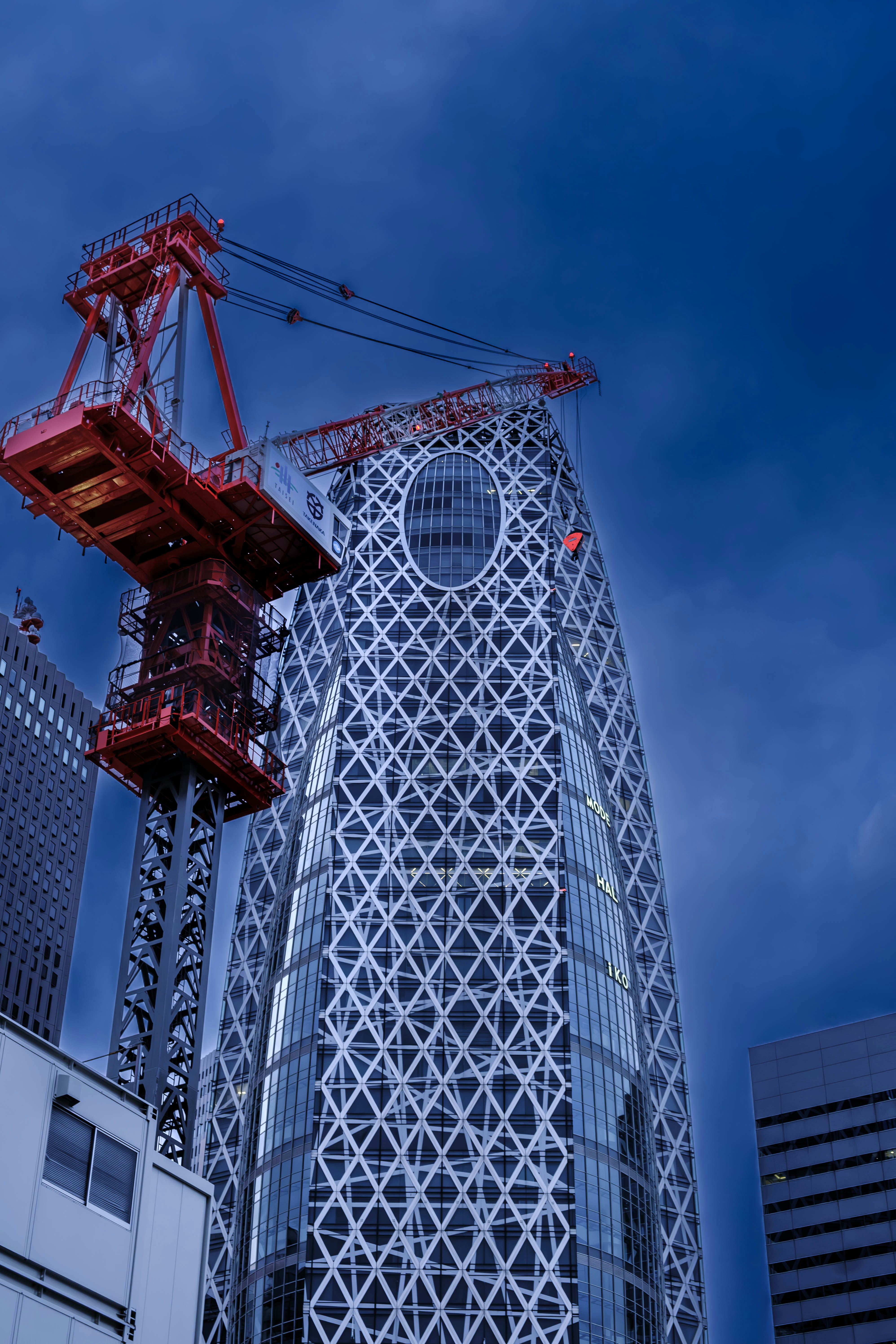Circle Window in a Diamond-Skin Skyscraper under a Red Crane