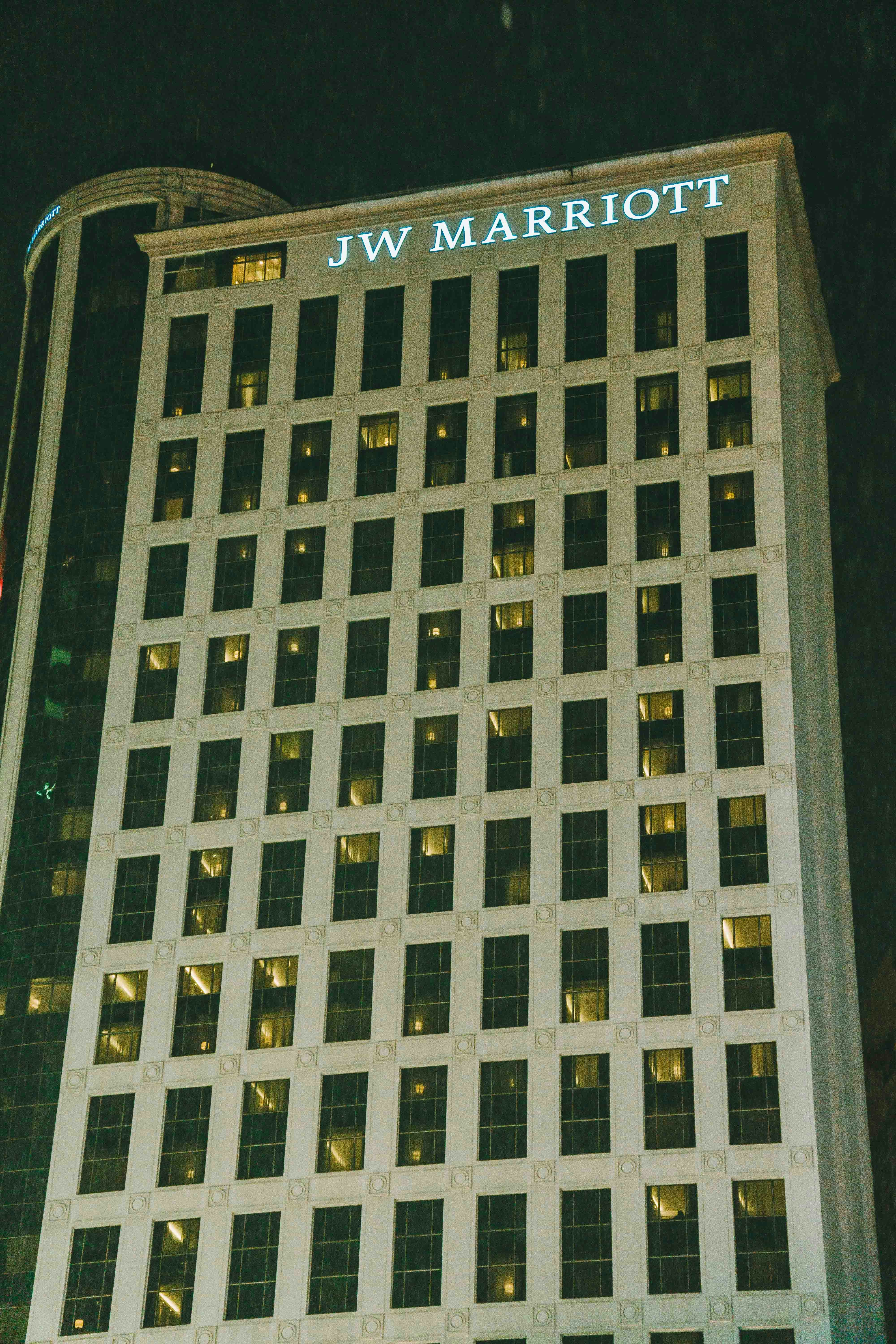 The JW Marriott hotel stands tall against the night sky, its illuminated windows reflecting urban sophistication.