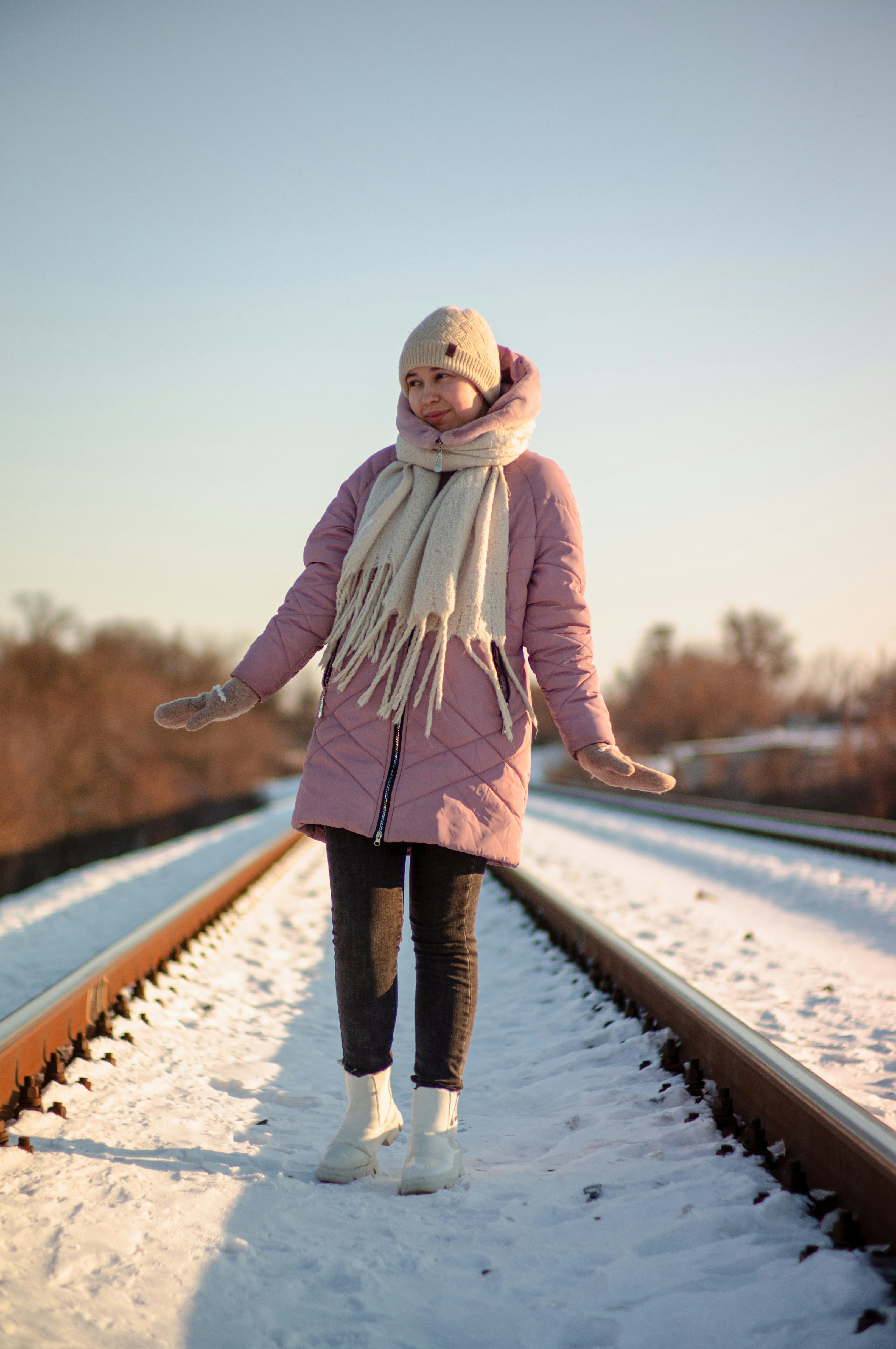 Dawn on the Rails: A lilac-wrapped figure balances on snow between converging tracks