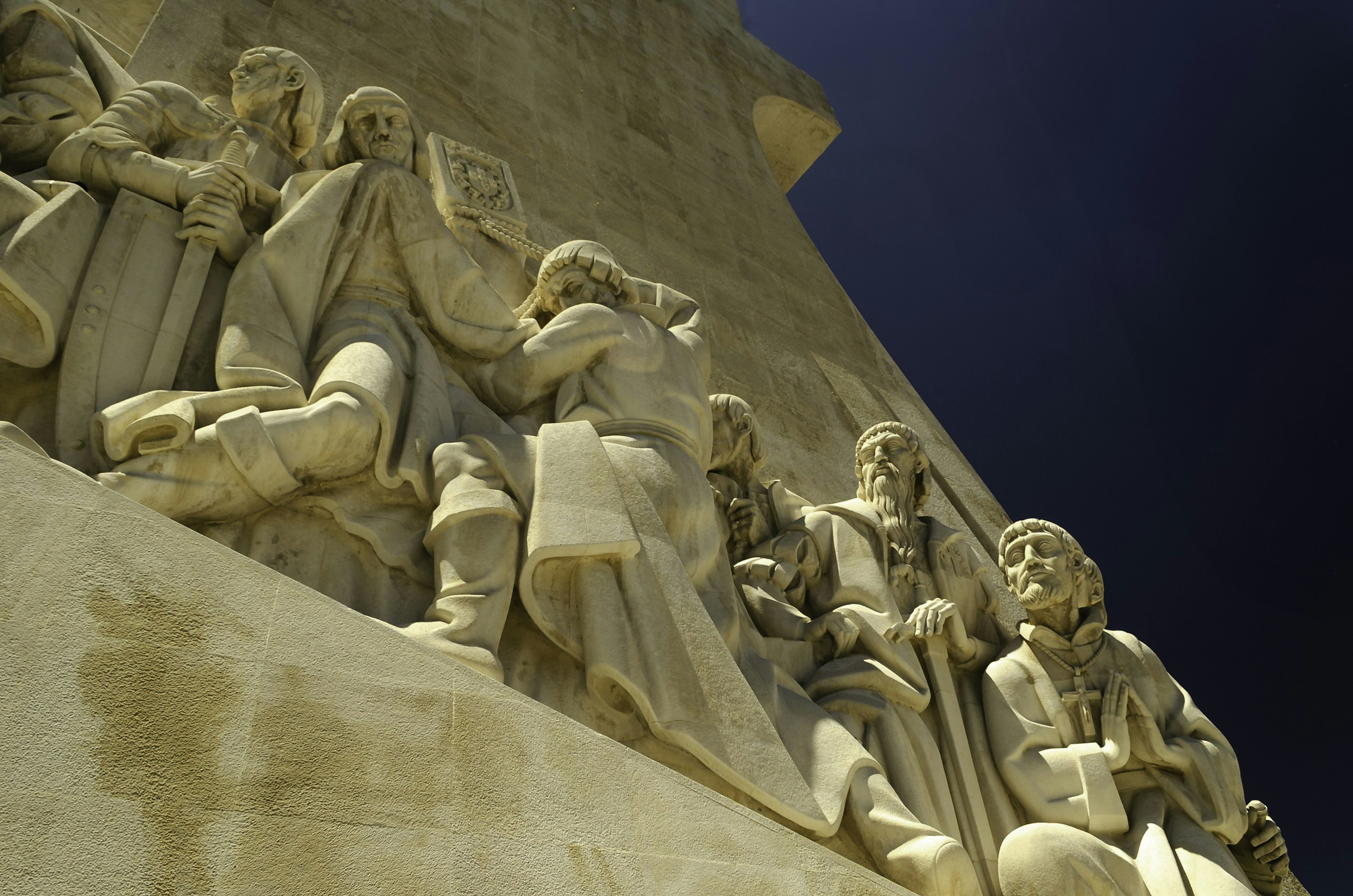 Lisbon, Portugal - May 25th 2019 - A close-up photo of the Monument of the Discoveries. The left side. | A close up of a statue of a group of people