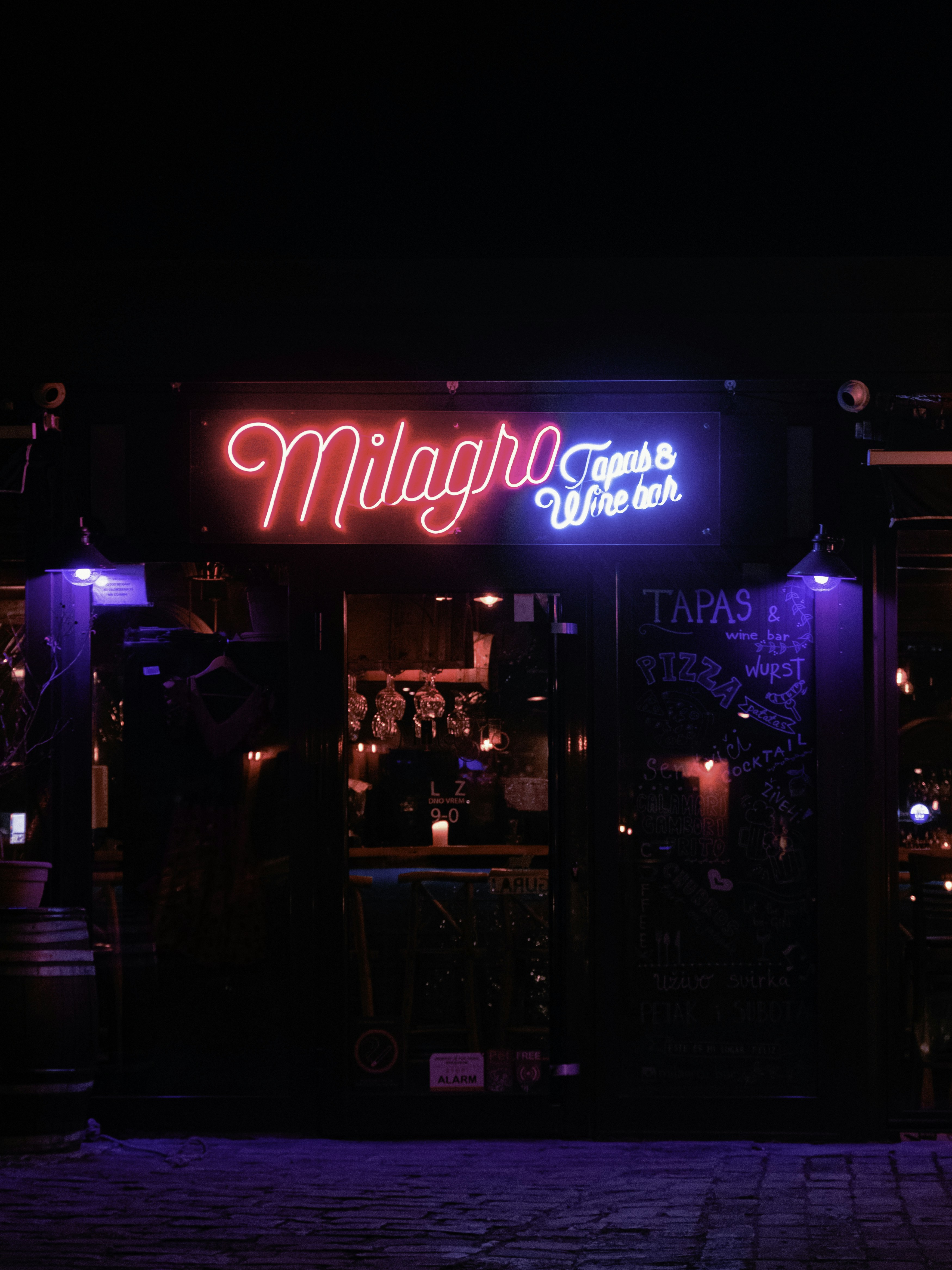 A couple of neon signs that are on the side of a building
