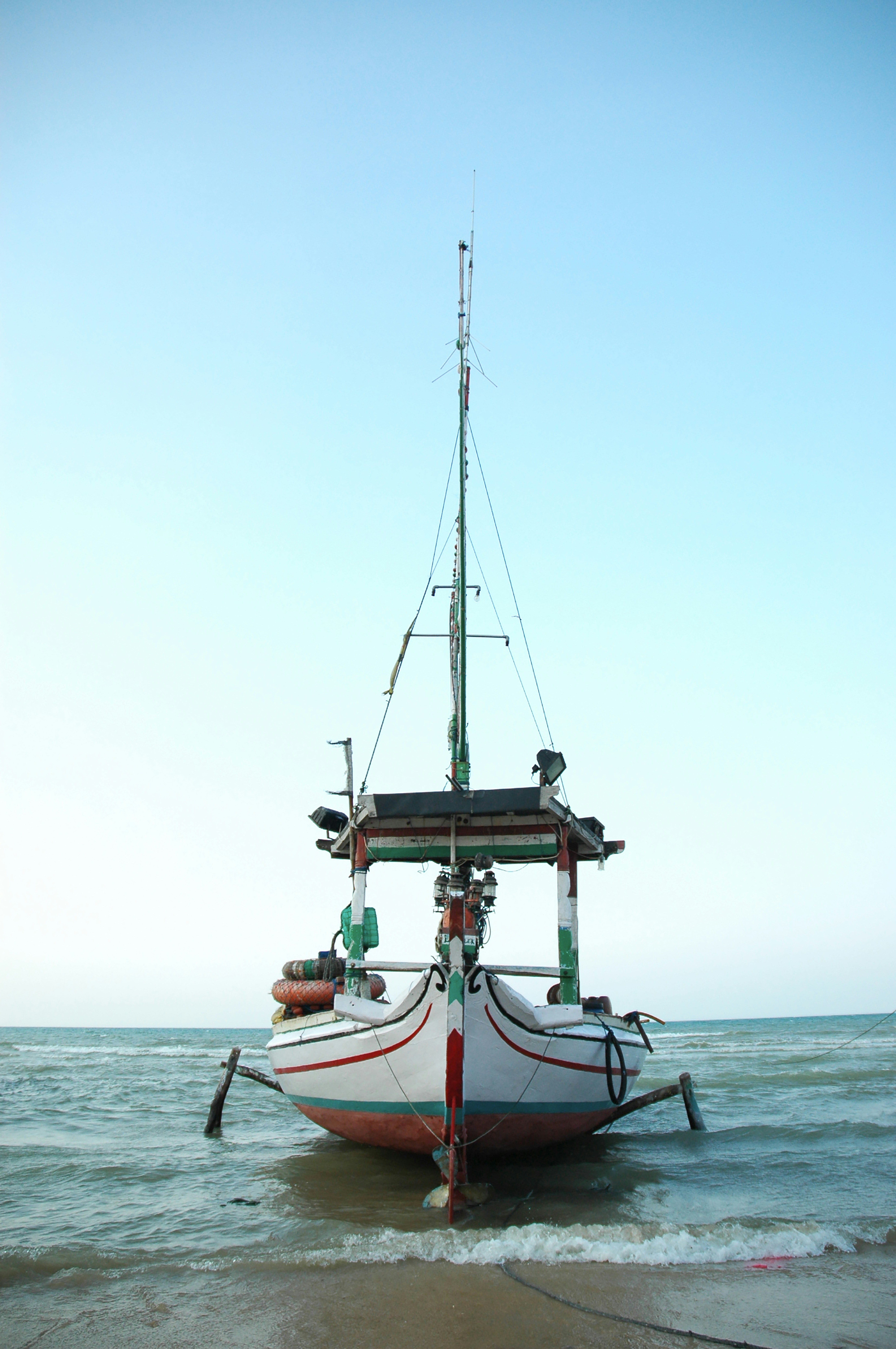 Beached Sailboat on a Quiet Horizon: A Colorful Vessel Anchored at Shore