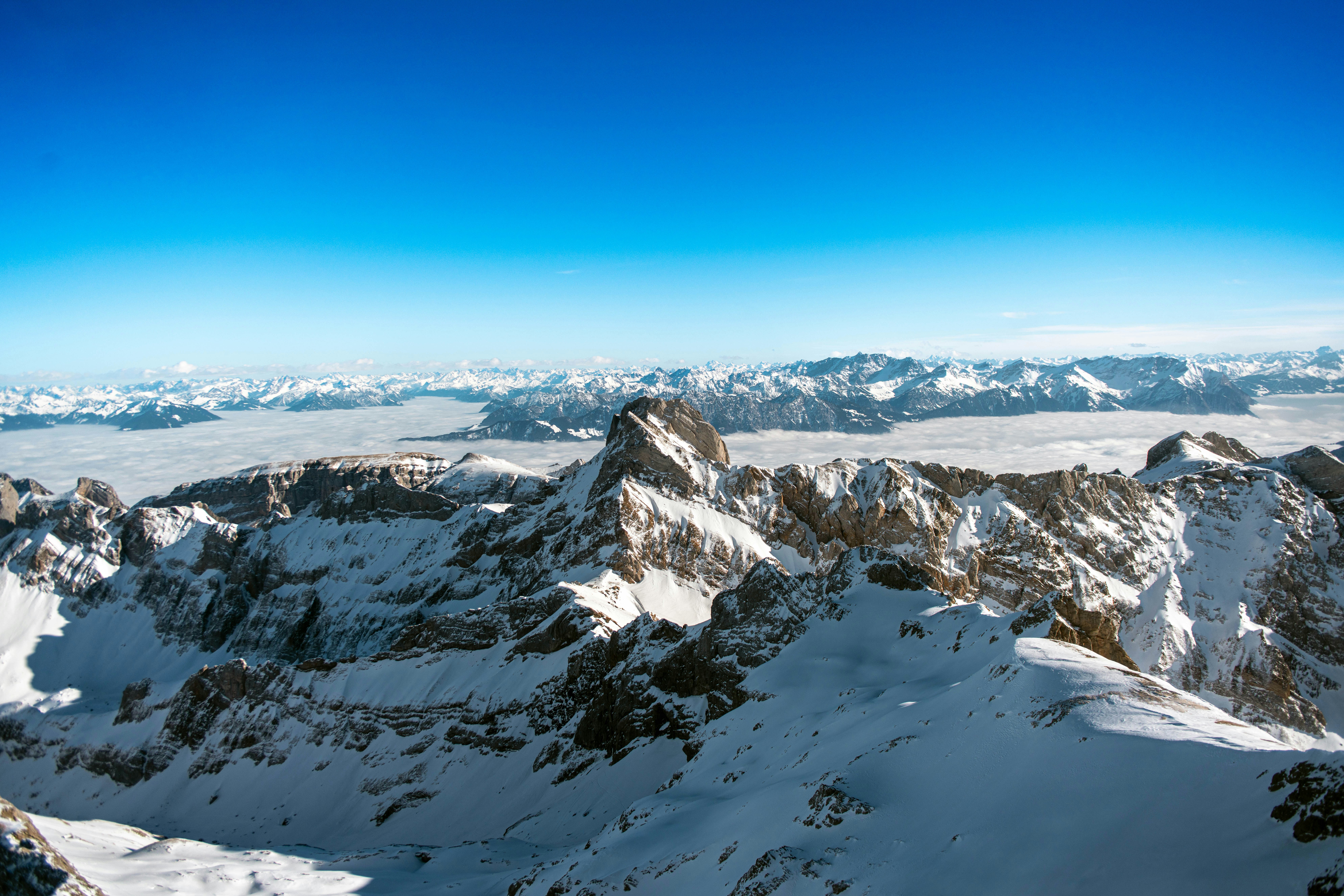 Snow-covered mountain range under a vibrant blue sky.