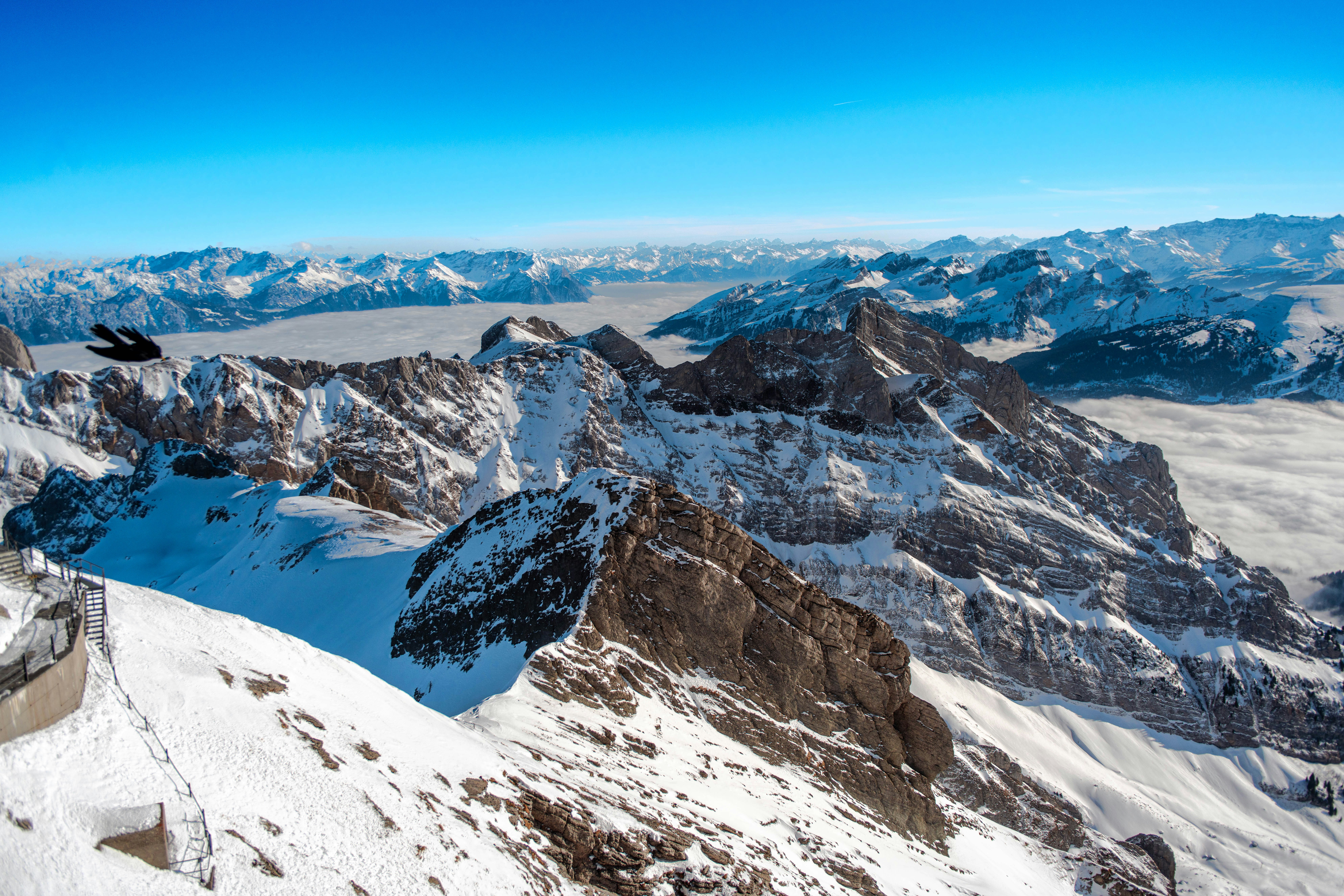 A snow covered mountain range with a lake in the middle photo – Free ...