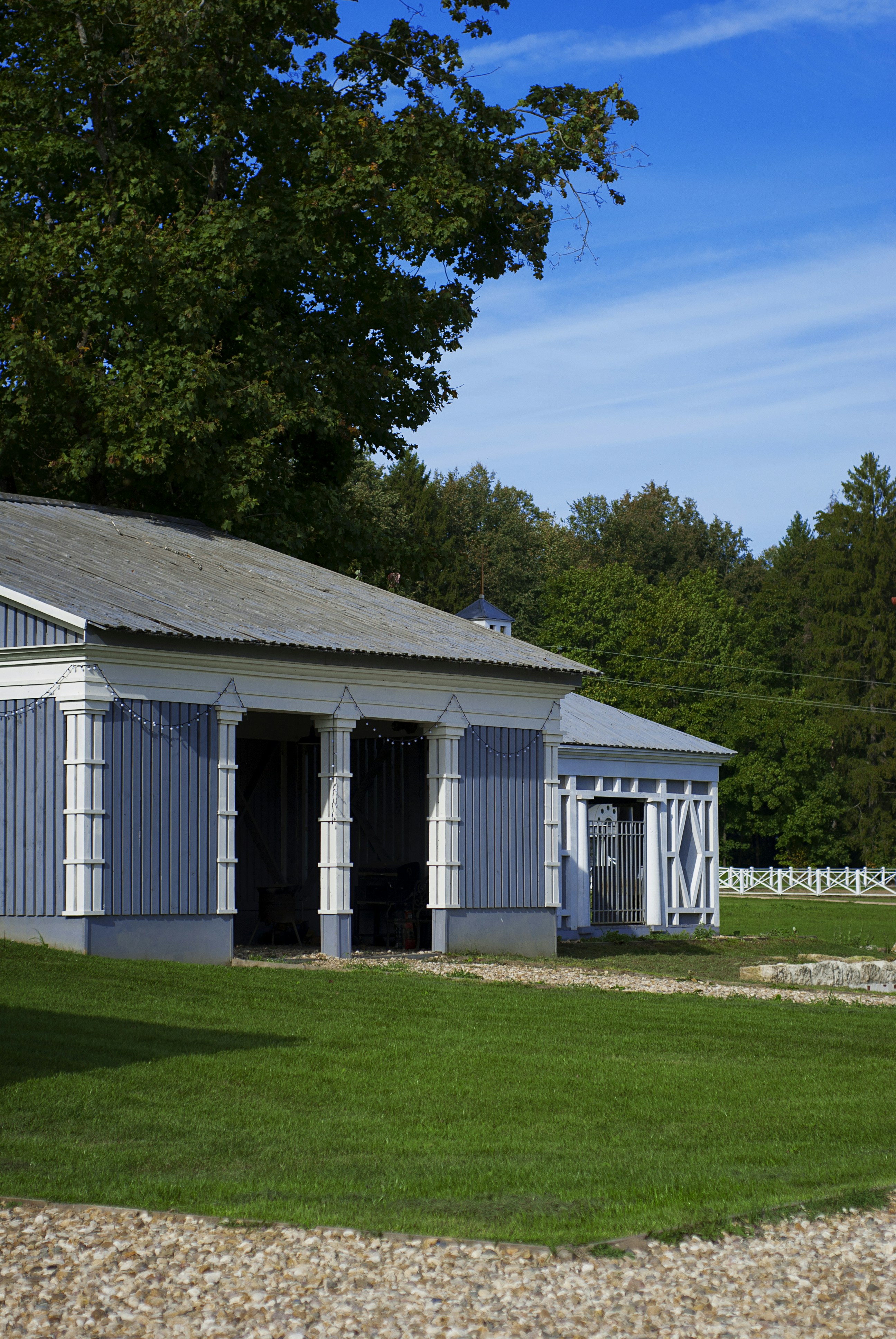 Blue-Paneled Pavilion with White Columns in a Sunlit Park