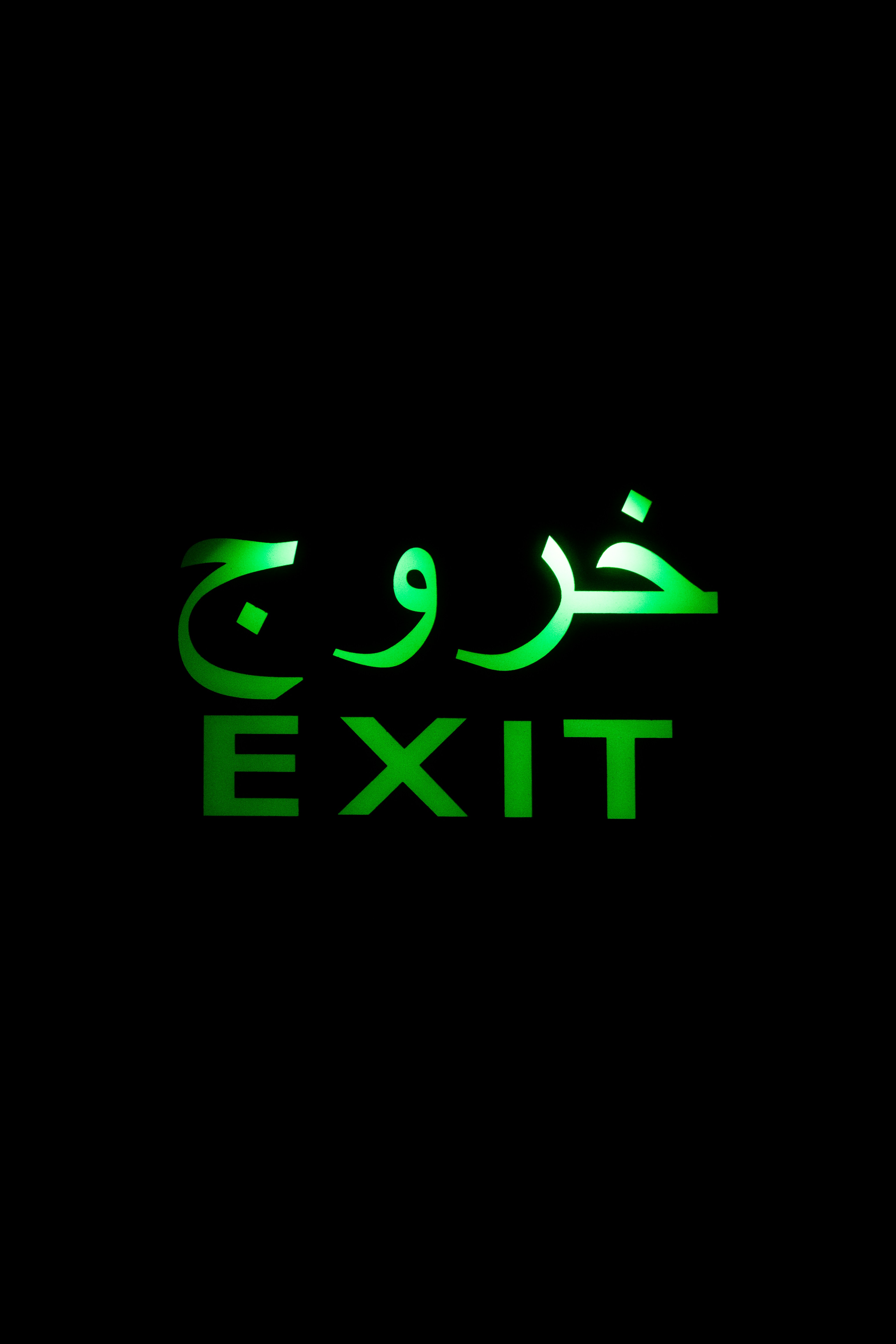 A green exit sign on a black background photo – Free Exit sign Image on ...