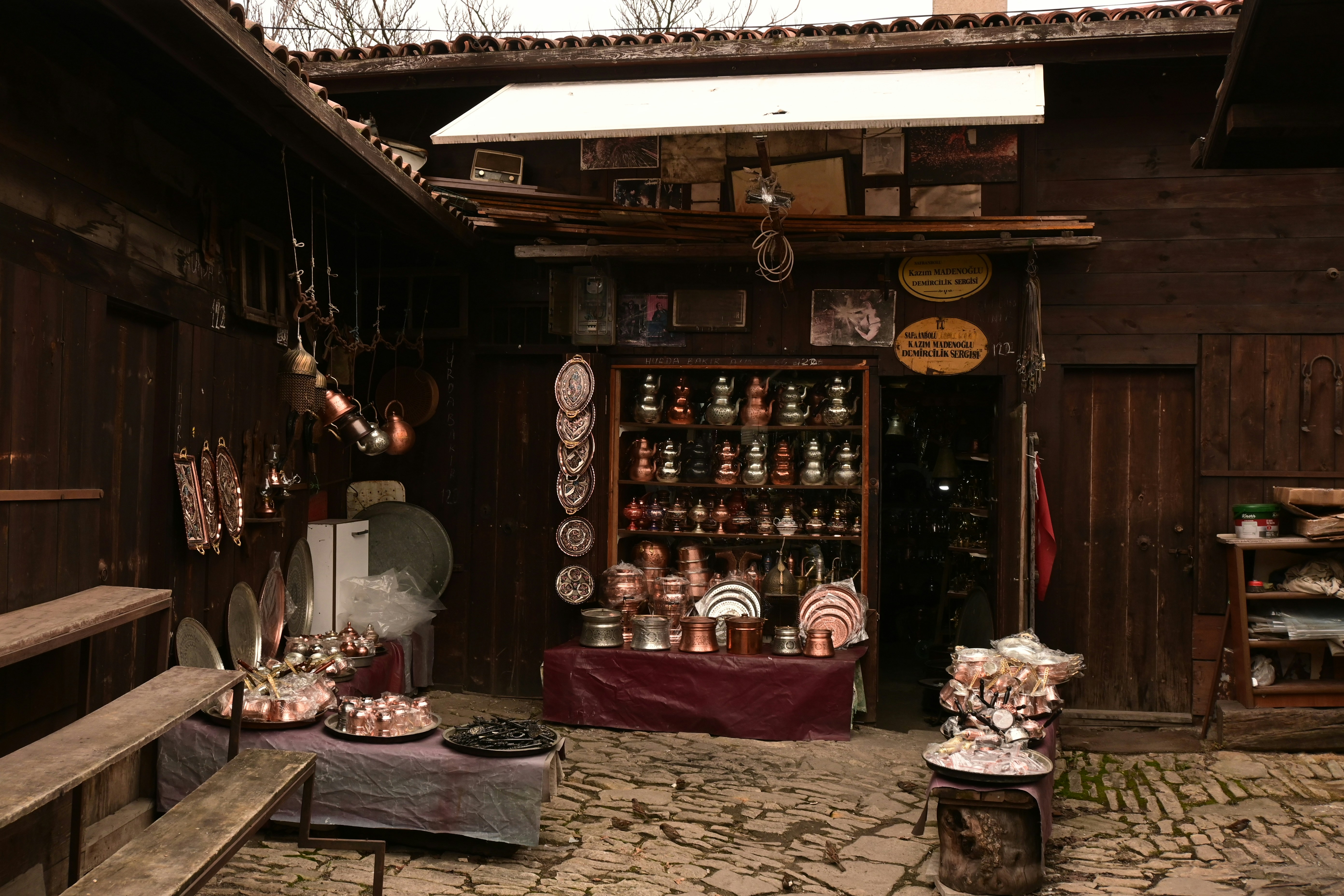 Display of handmade ironware in a rustic wooden stall at Safranbolu's old bazaar.
